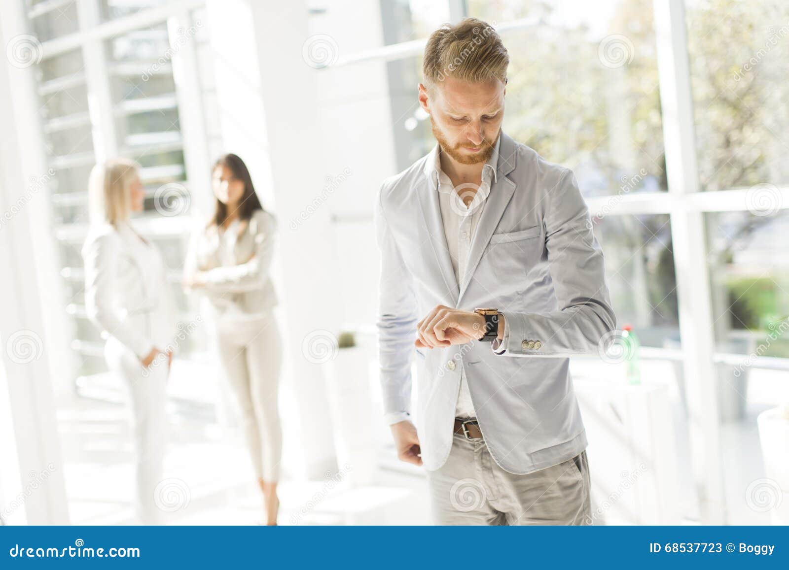 Young Man Looking at Watch in the Office Stock Image - Image of looking ...