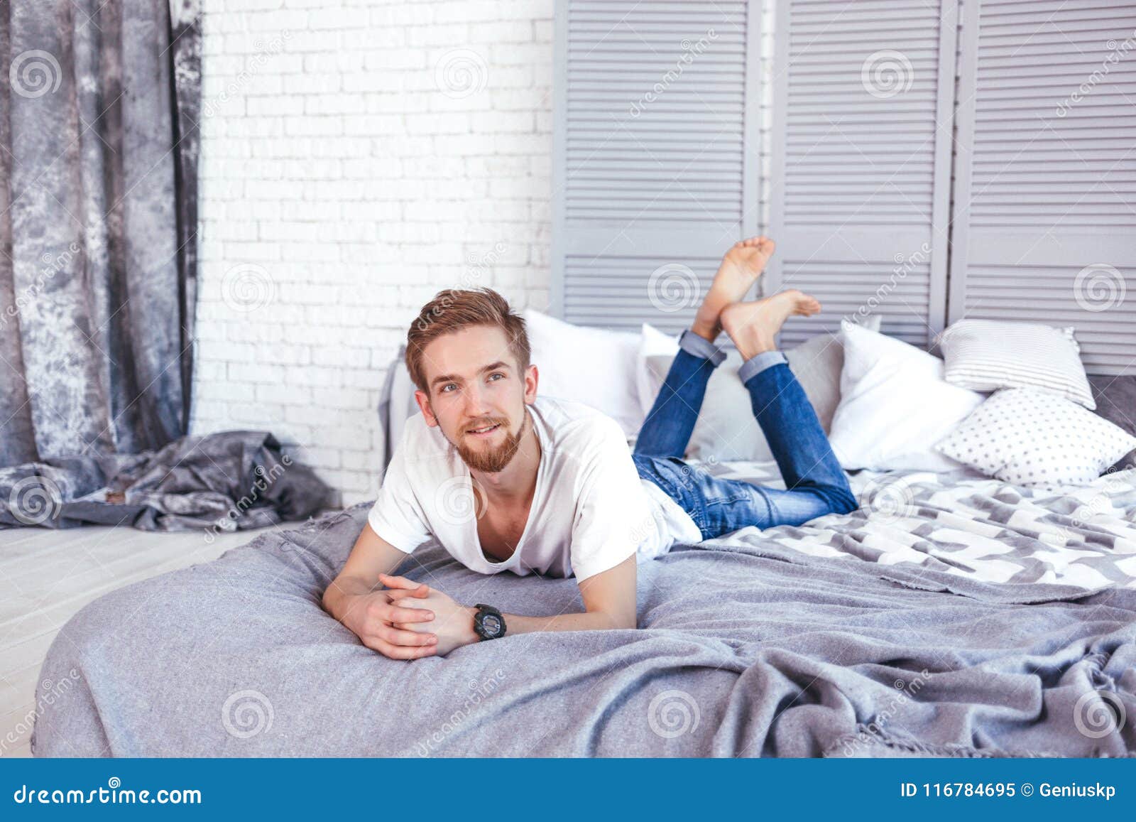 Young man lying in bed stock image. Image of attractive - 116784695