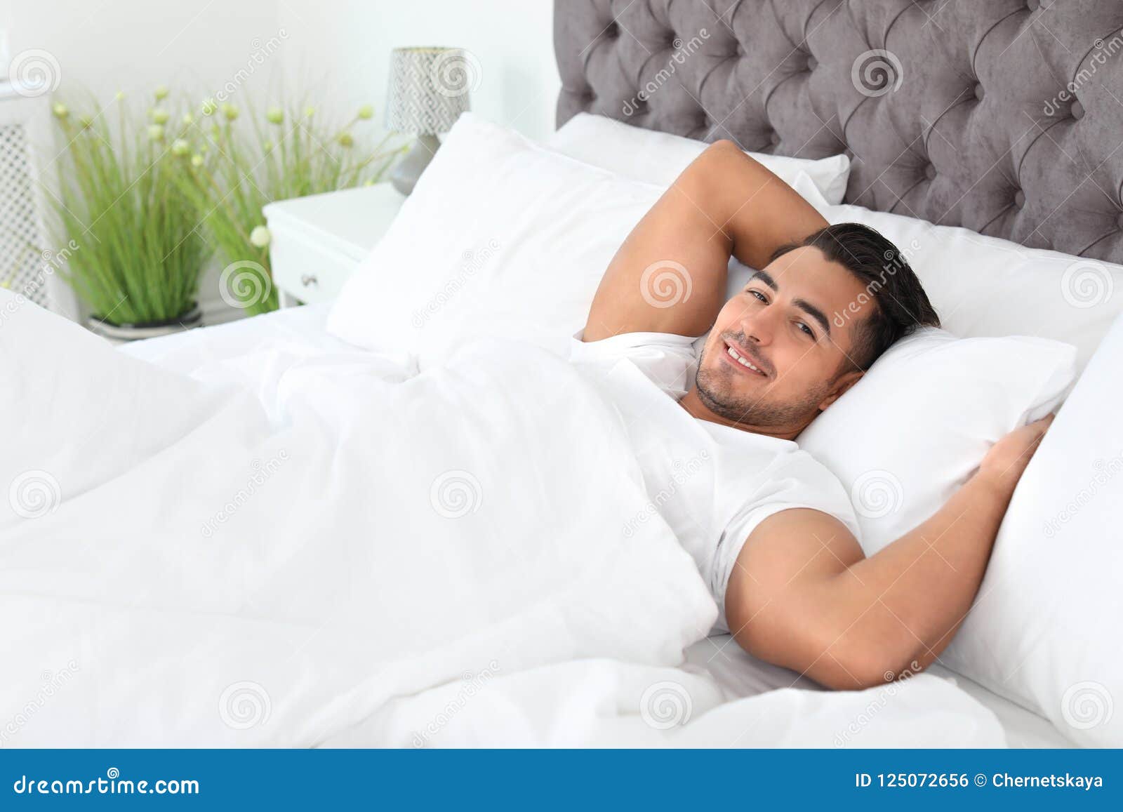 Young Man Lying in Bed with Soft Pillows Stock Photo - Image of male ...