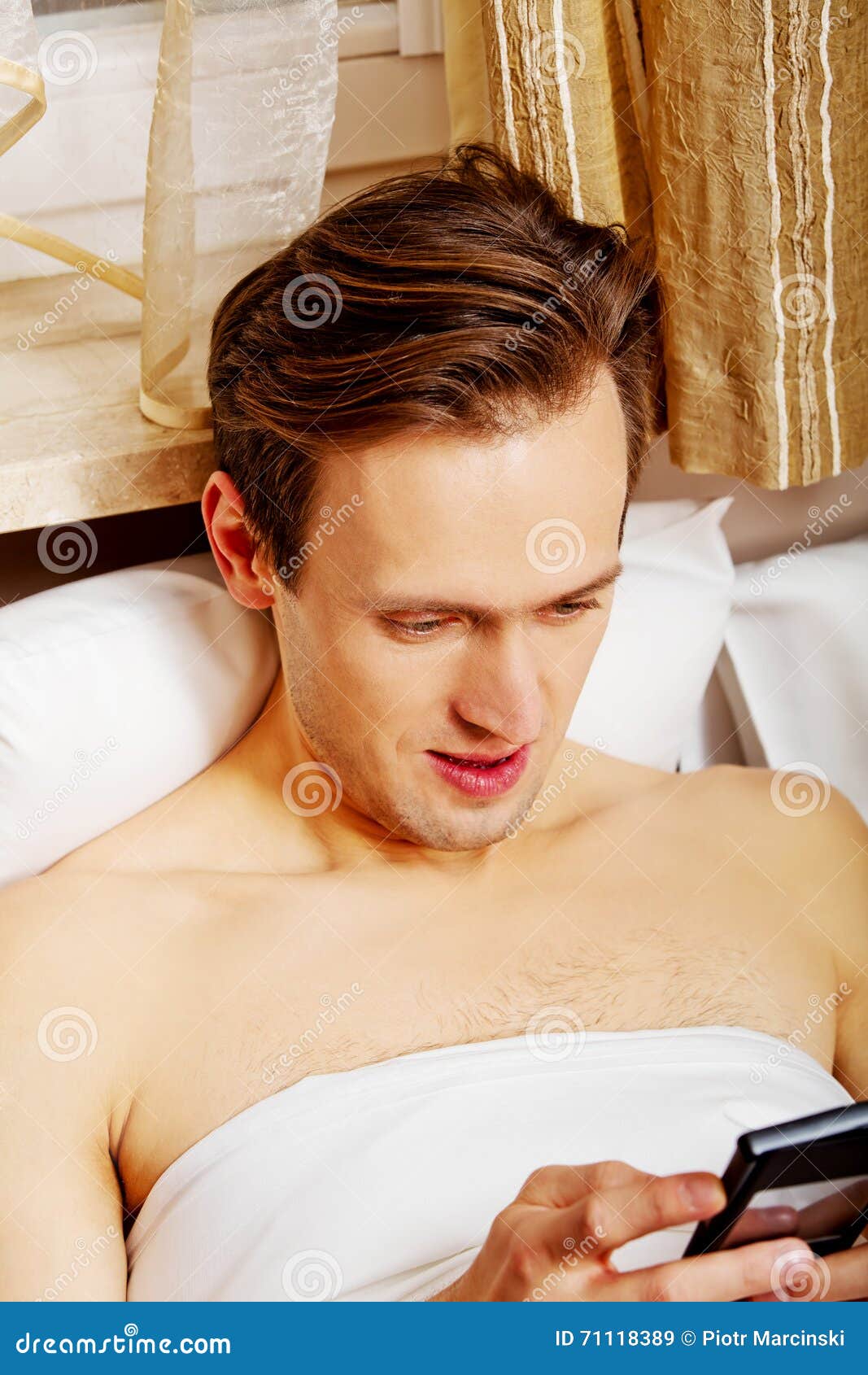 Young Man Lying on Bed and Using Mobile Phone Stock Image - Image of ...