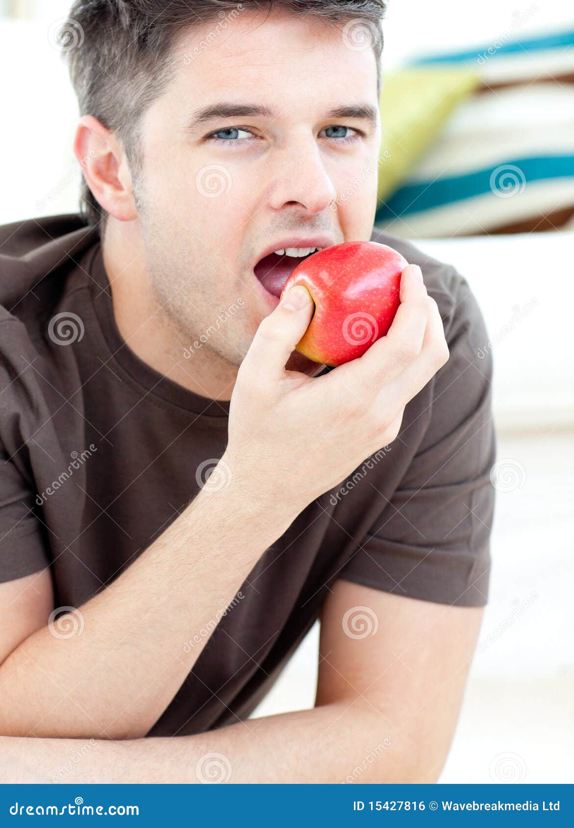 Young Man Lying on the Floor Eating a Red Apple Stock Photo - Image of ...