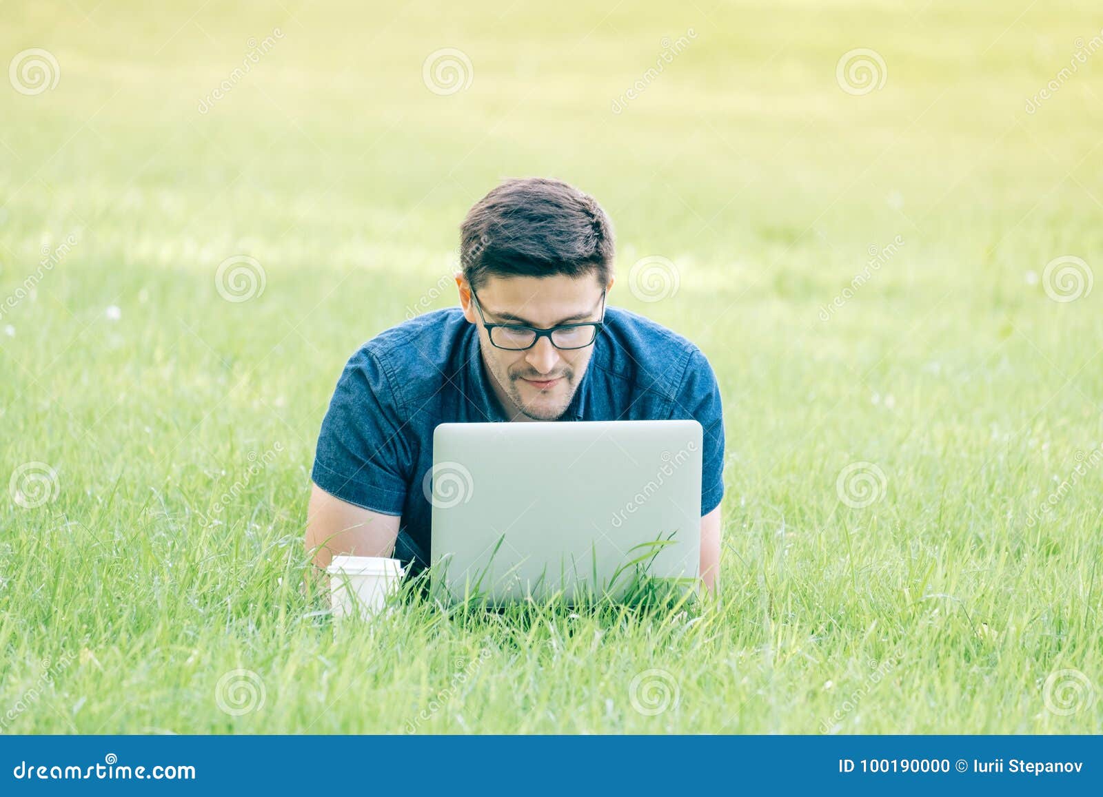 Young Man Lying on Grass and Using Laptop Stock Photo - Image of ...