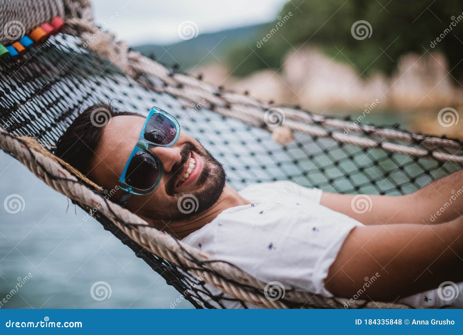 Young Man Lying in a Hammock by the Ocean. a Handsome Guy is Resting in ...
