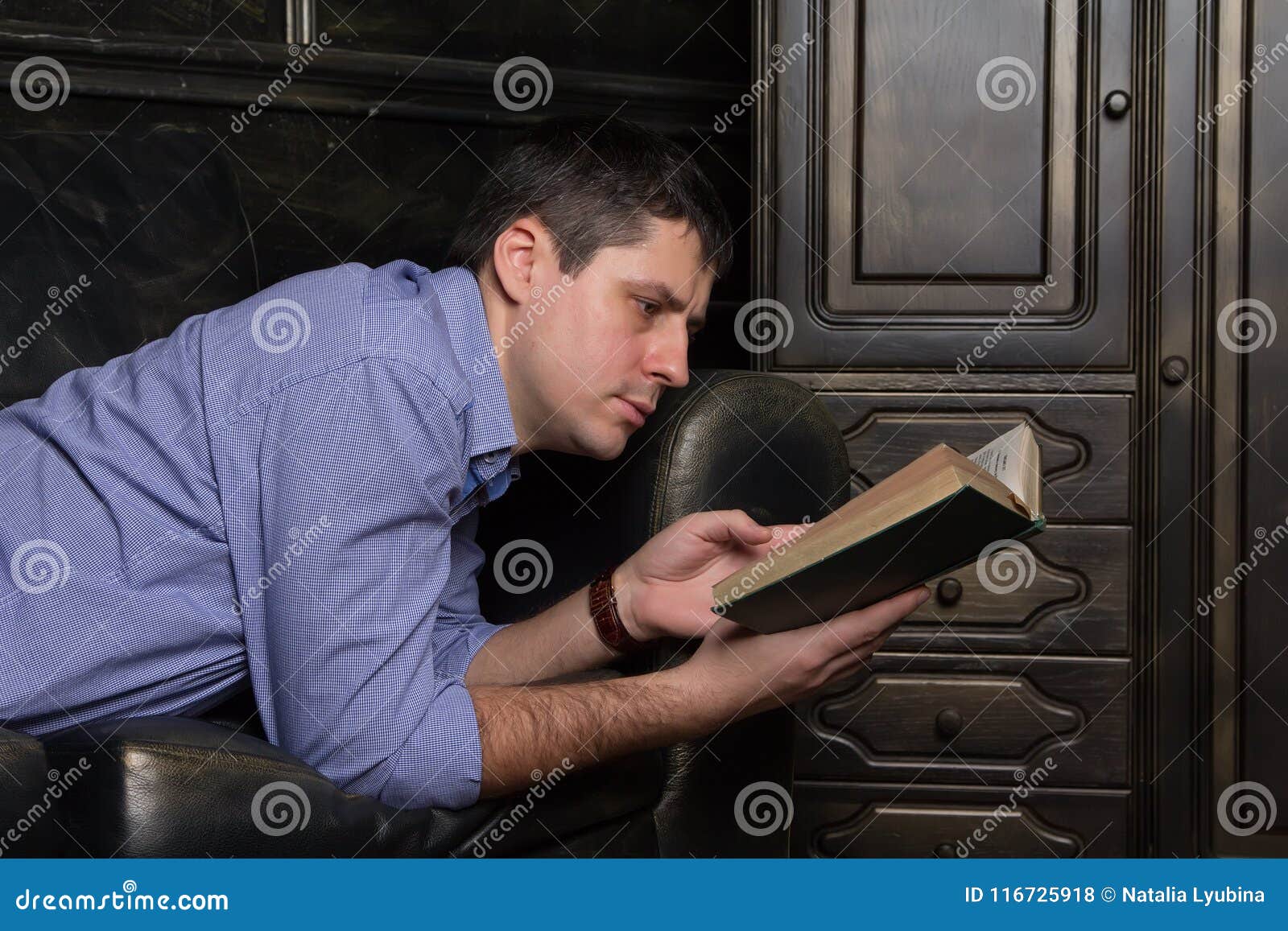 Young Man is Lying on the Sofa and is Reading a Book Stock Photo ...