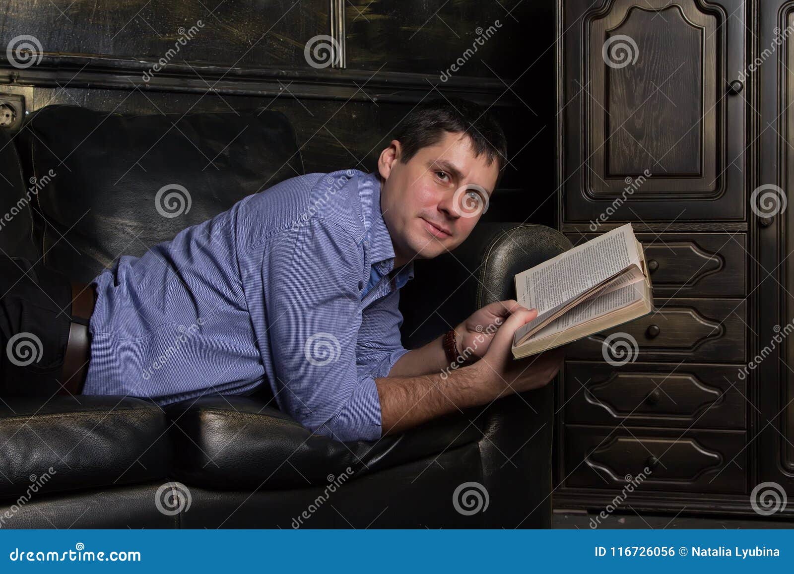 Young Man is Lying on the Sofa and is Reading a Book Stock Photo ...