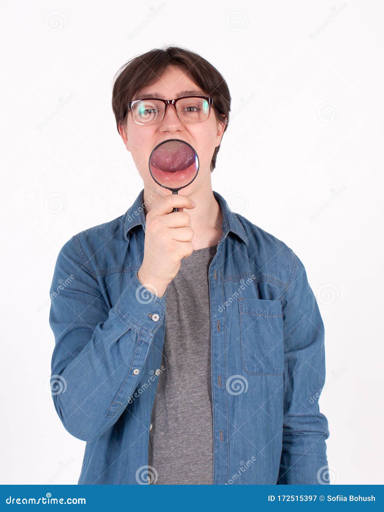 Young Man with Magnifying Glass on Grey Background. Curious Young Man ...