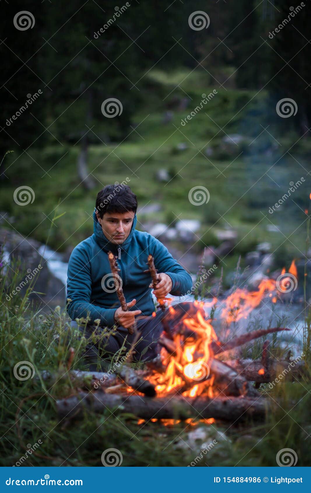 Young Man Making Fire while Camping Outdoors Stock Photo - Image of ...