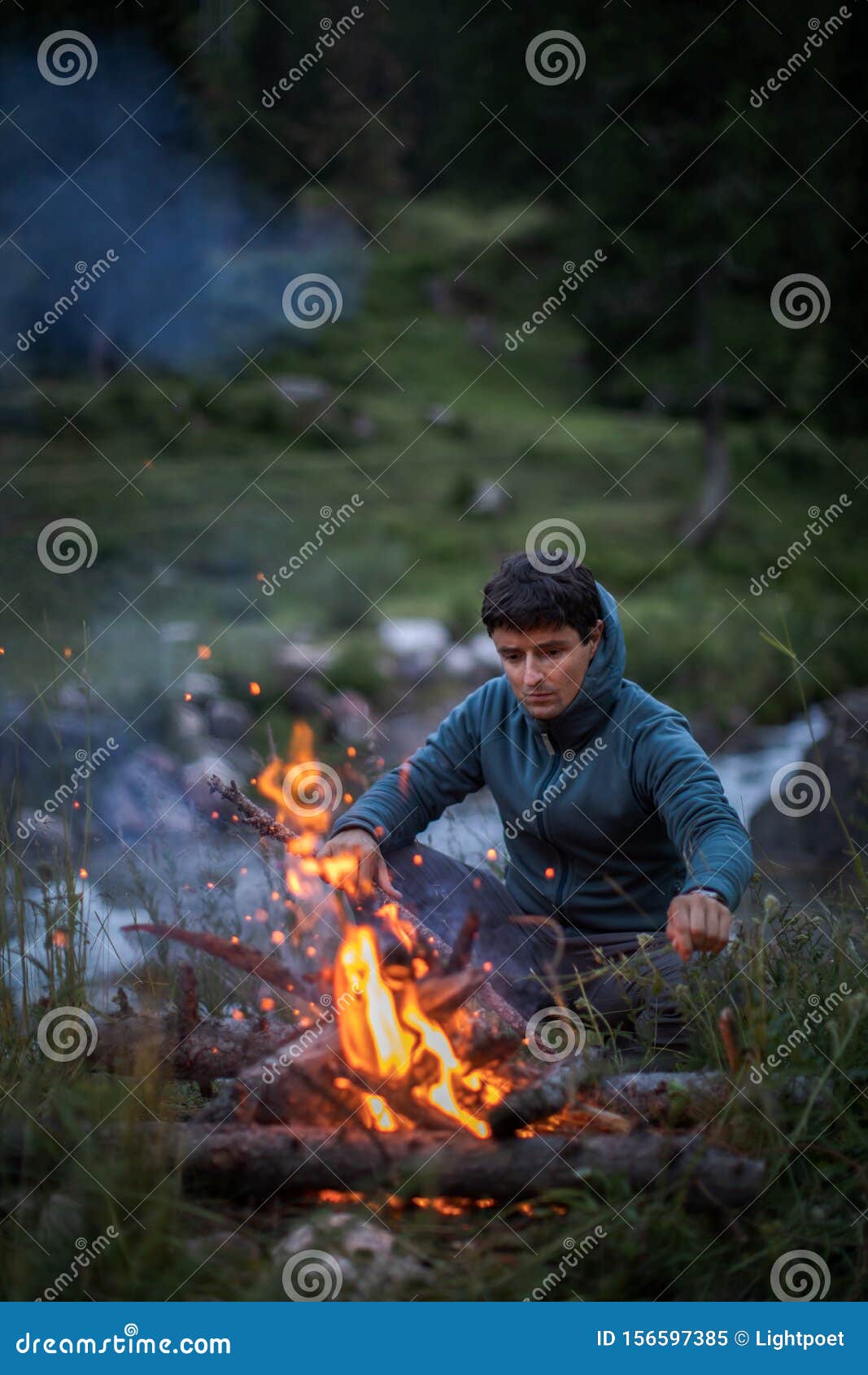 Young Man Making Fire while Camping Outdoors Stock Image - Image of ...