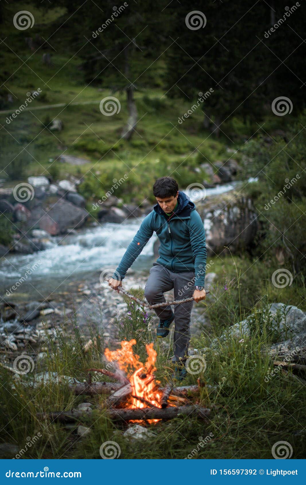 Young Man Making Fire while Camping Outdoors Stock Photo - Image of ...