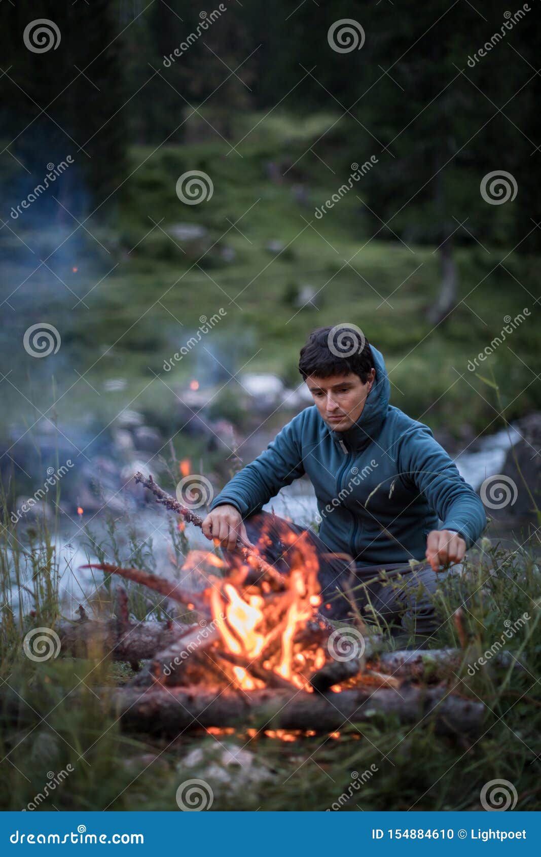 Young Man Making Fire while Camping Outdoors Stock Photo - Image of ...
