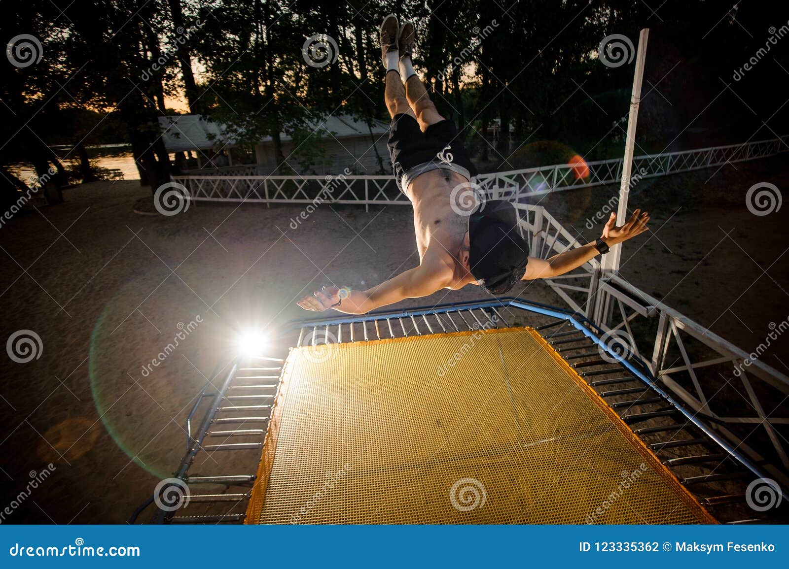 Young Man Making Flip on the Trampoline Stock Photo - Image of shorts ...
