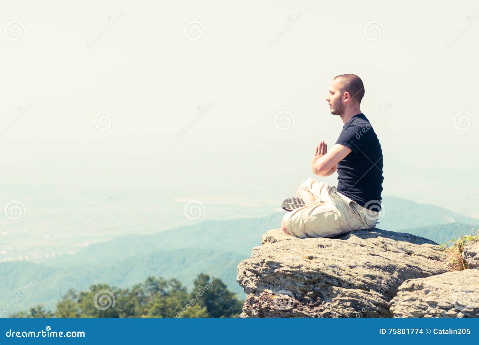 Young Man Meditating on Top of the Mountain Stock Photo - Image of ...