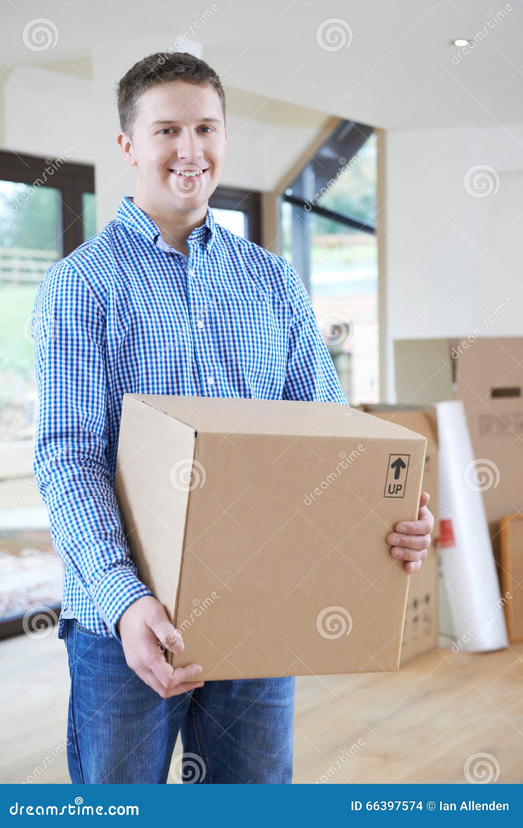 Young Man Moving into New Home Stock Photo - Image of room, face: 66397574
