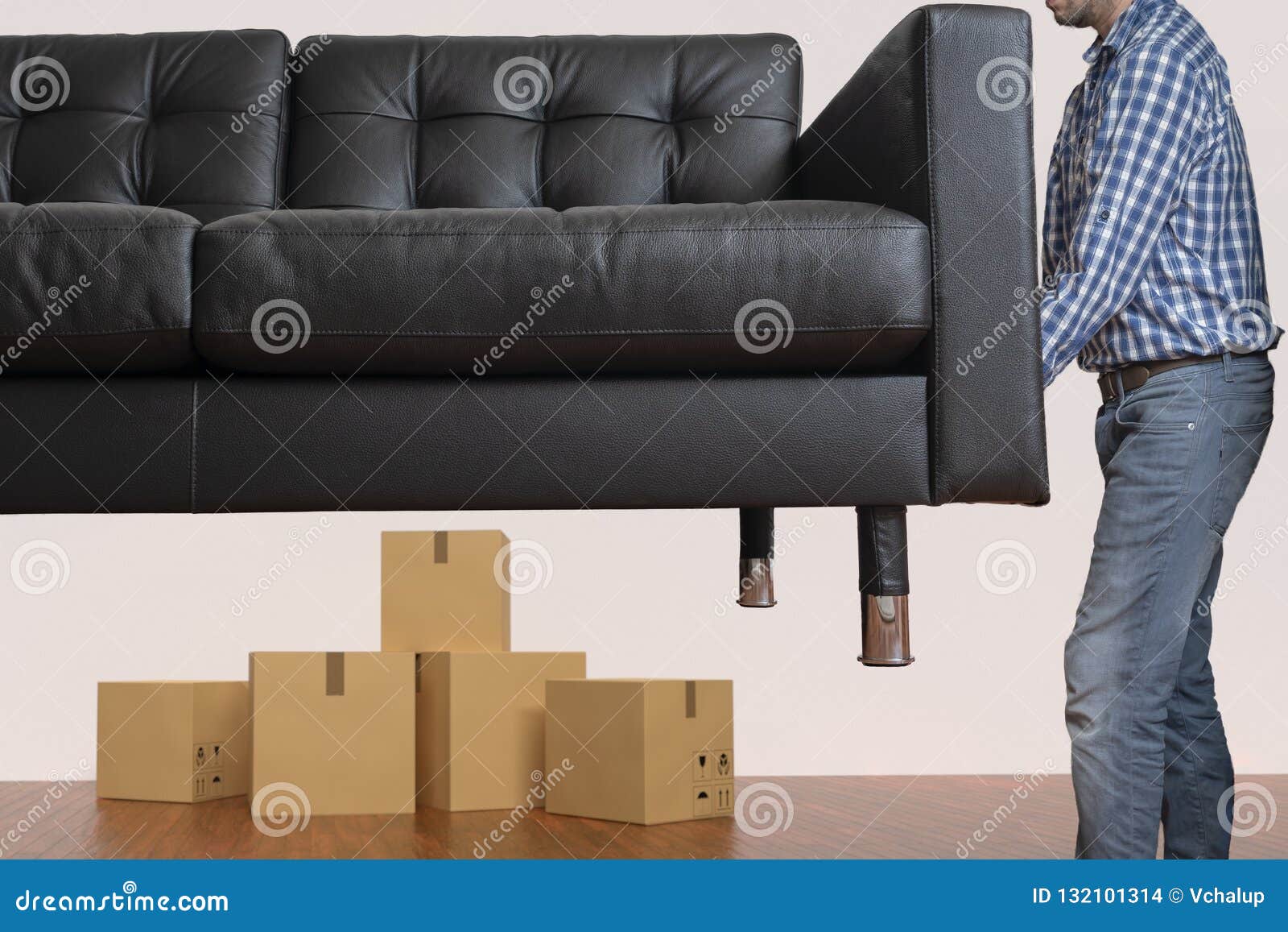 Young Man is Moving Sofa. Moving To a New House Concept. Stock Photo ...