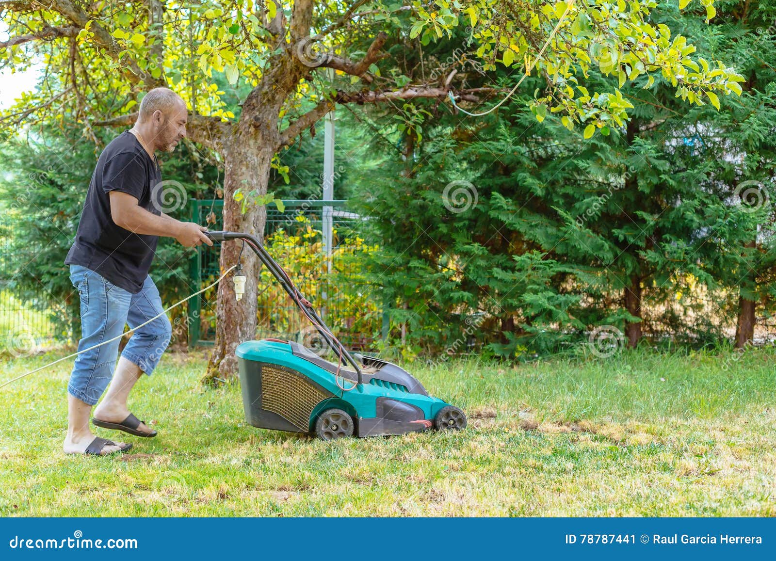 Young Boy Mowing Grass With Lawn Mower, His Mother And Sister ...