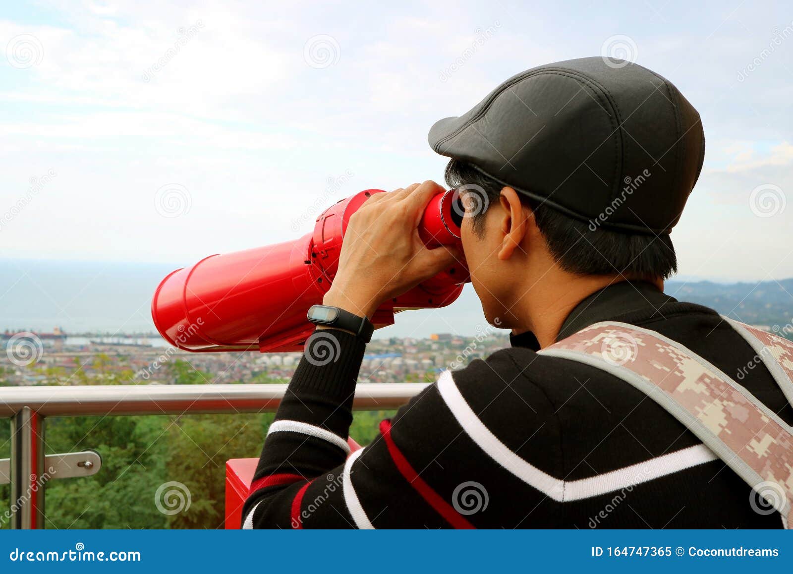 Young Man Observing Aerial City View with Binoculars from the ...