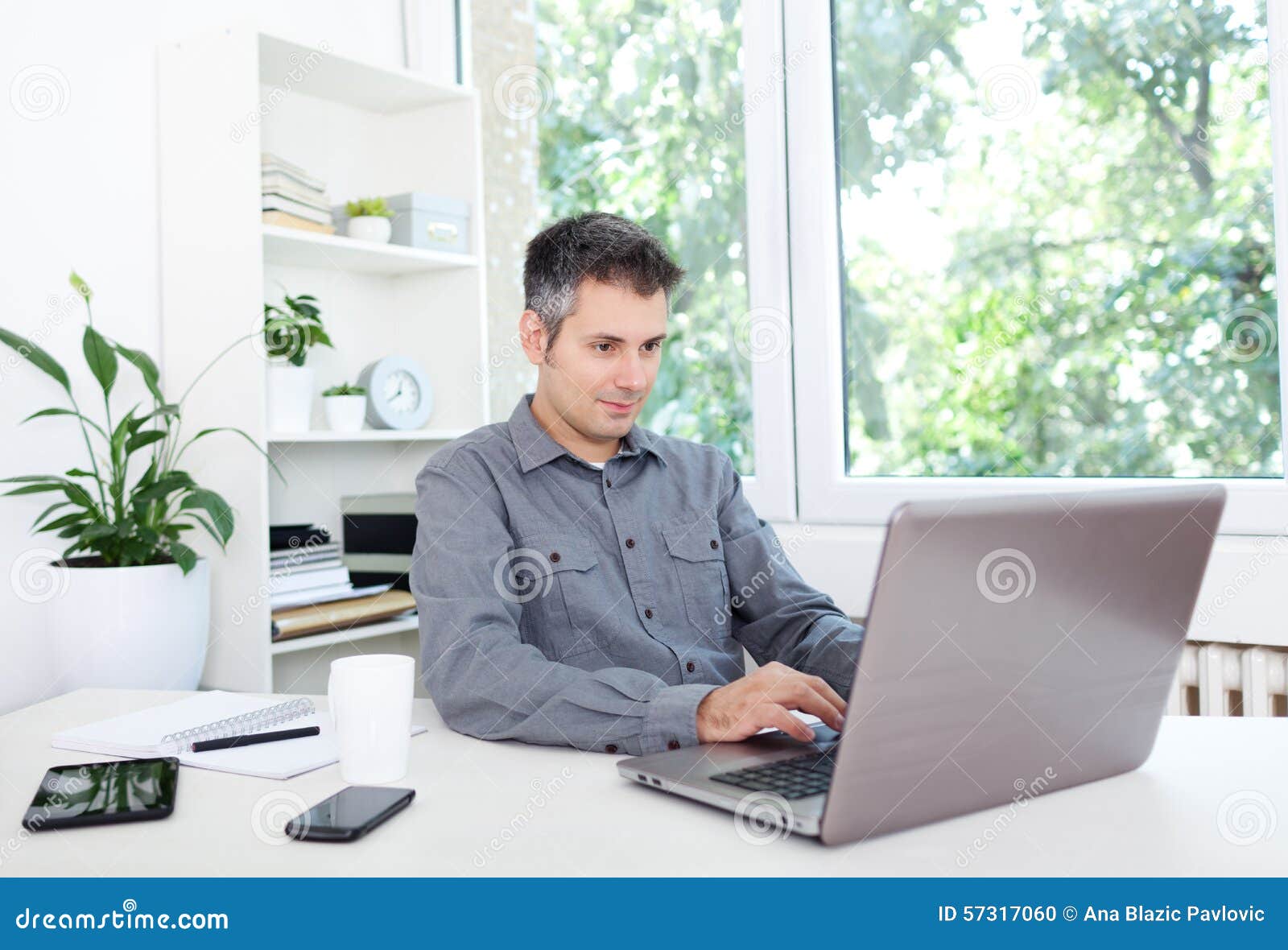 Young Man at Office Desk, Working on Laptop Stock Photo - Image of grey ...