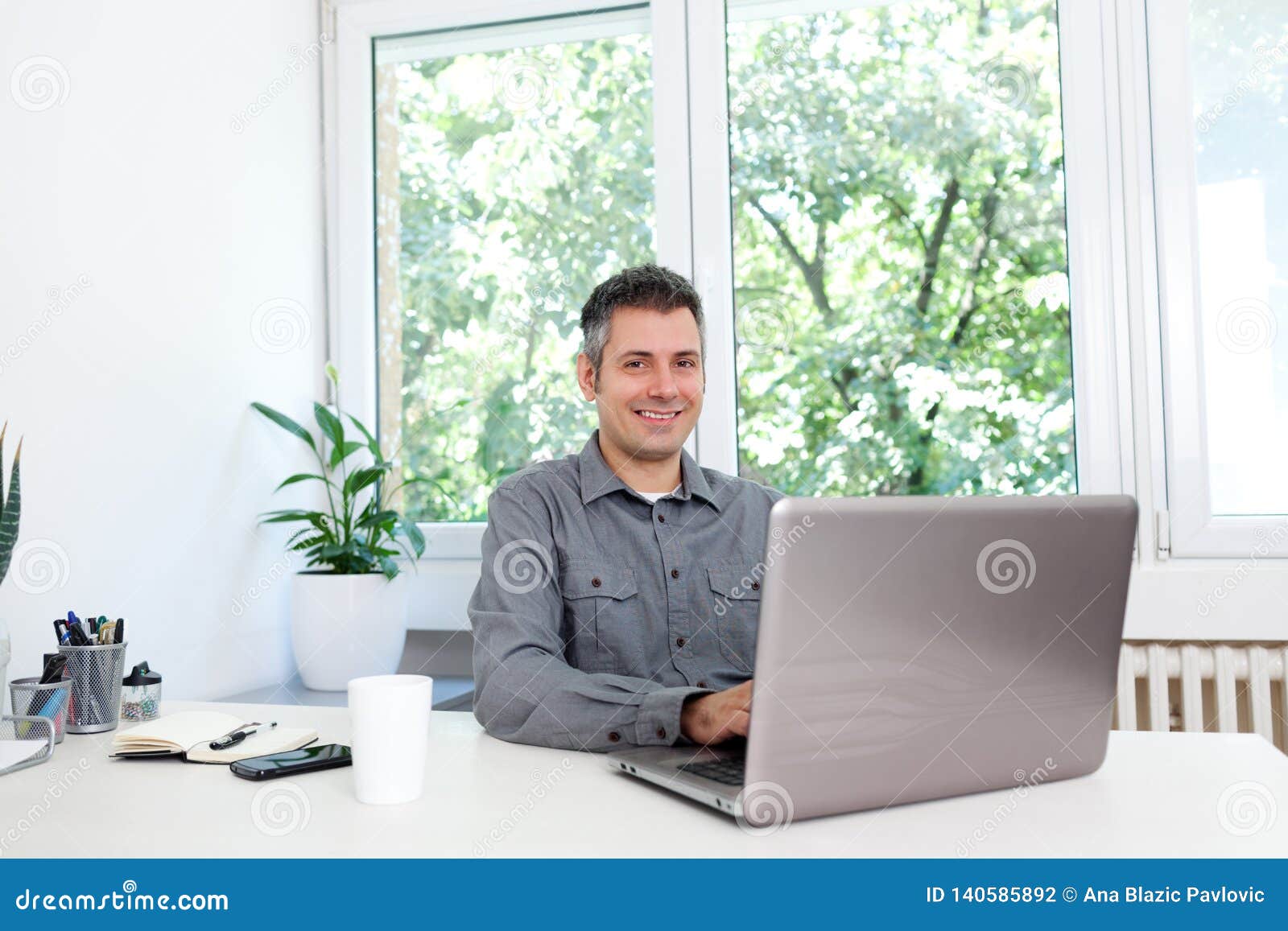 Young man at the office stock photo. Image of businessman - 140585892