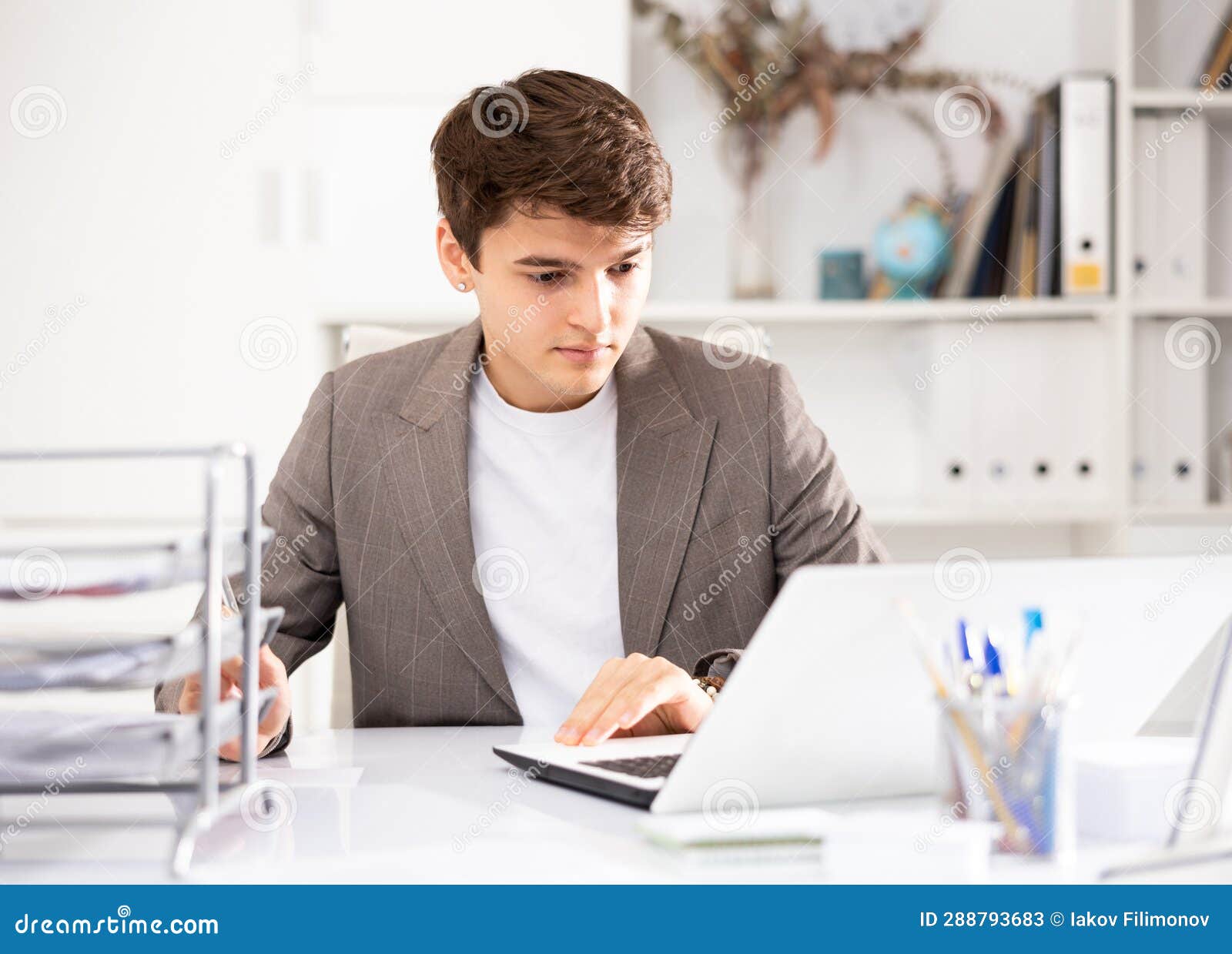 Young Man Office Manager Sitting at Table and Using Laptop Computer ...