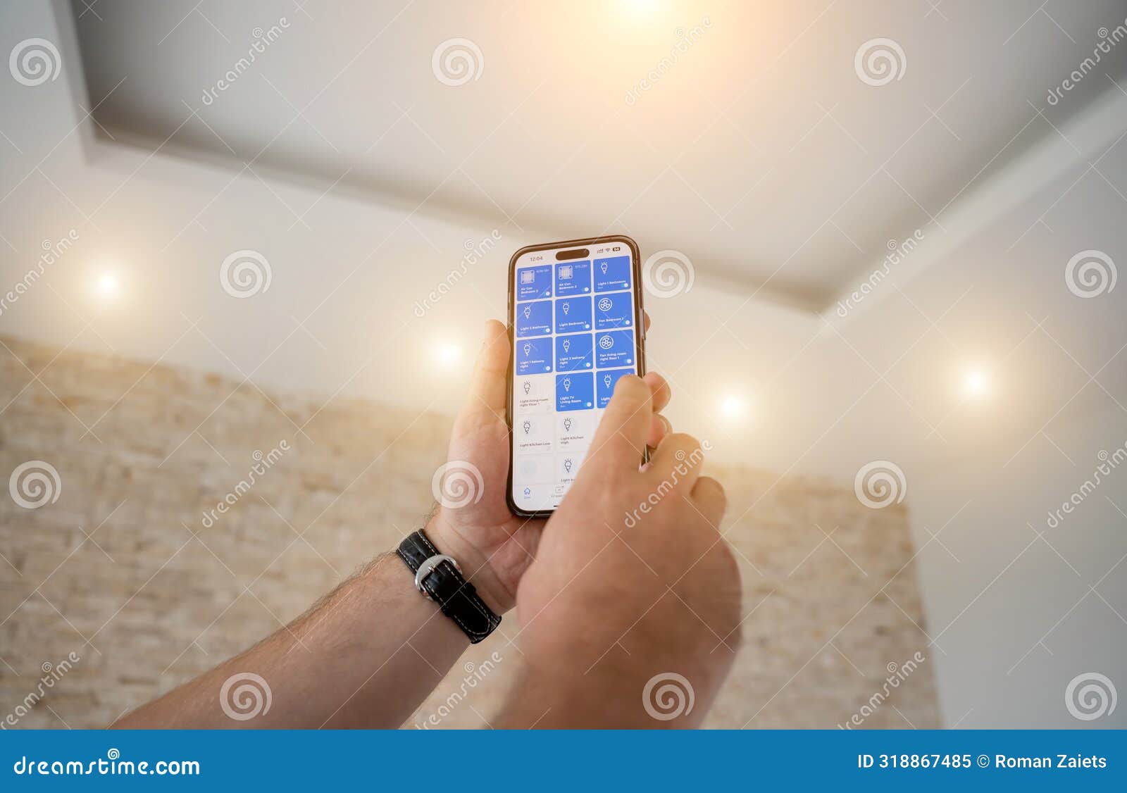 Young Man Operates Wireless Lightning System in a Modern Apartment ...