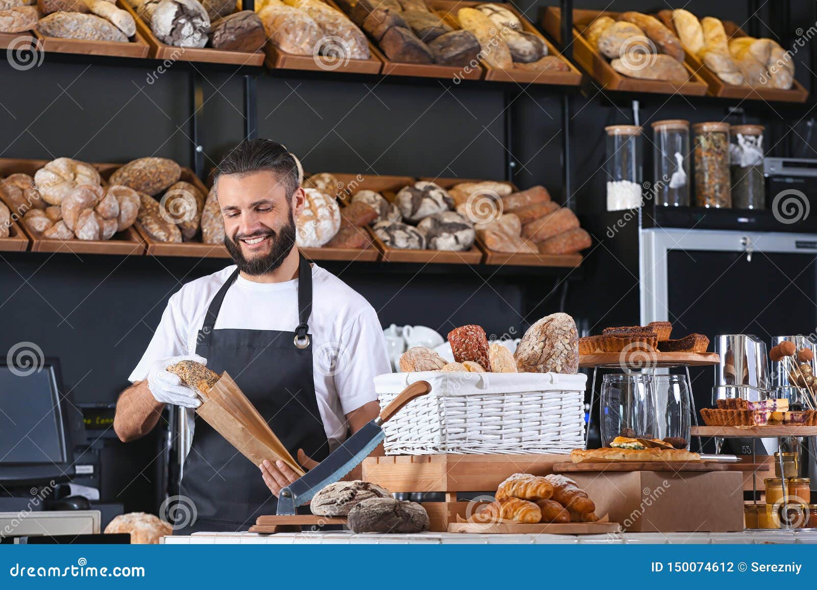 Young Man Packaging Bread for Customer in Bakery Stock Photo - Image of ...