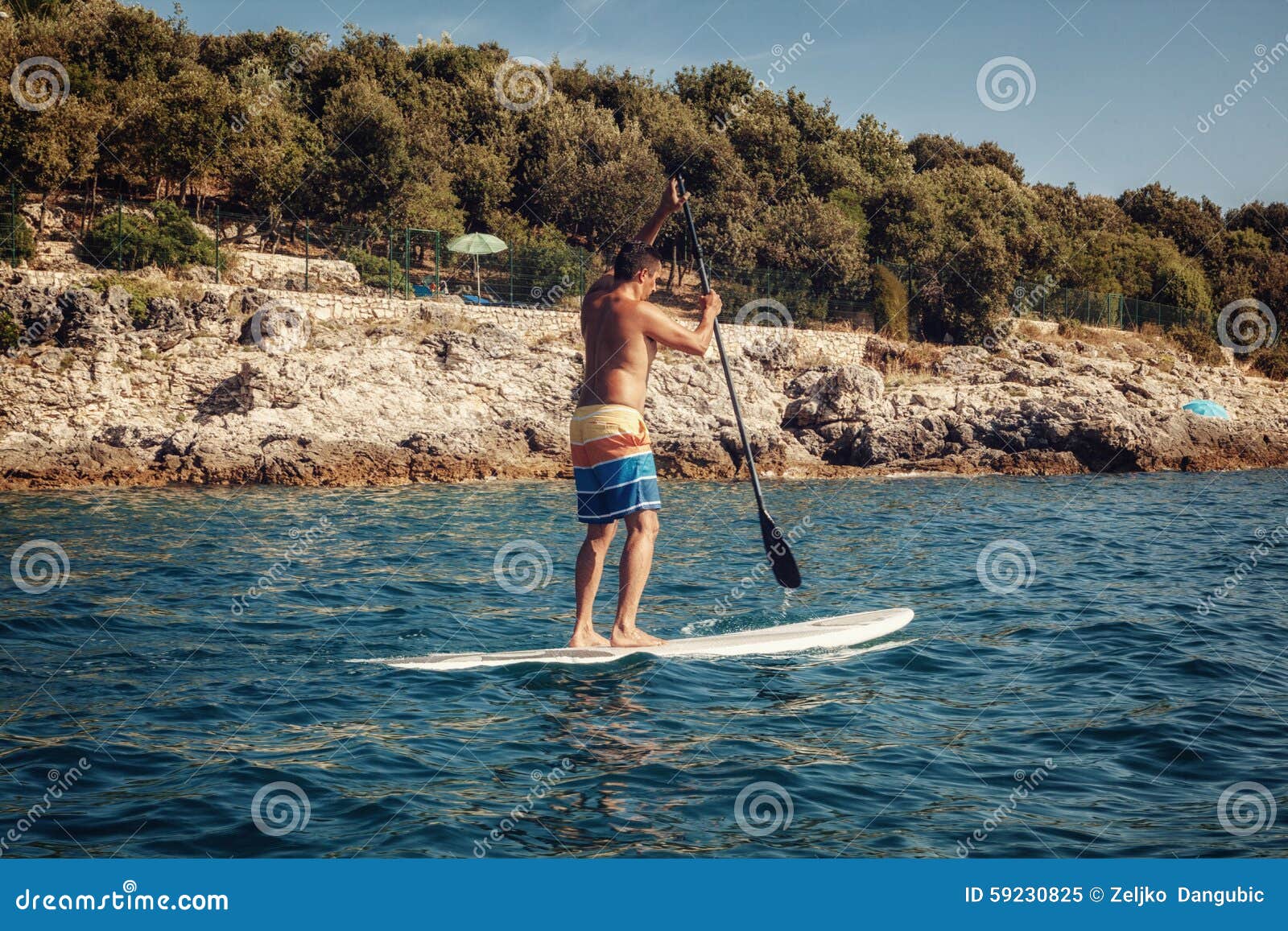 Young Man Paddleboarding stock image. Image of dusk, sport - 59230825
