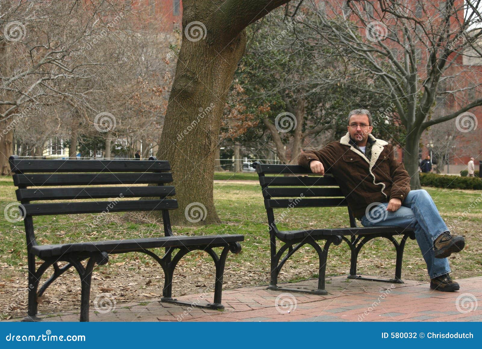 Young man on park bench stock photo. Image of coat, america - 580032