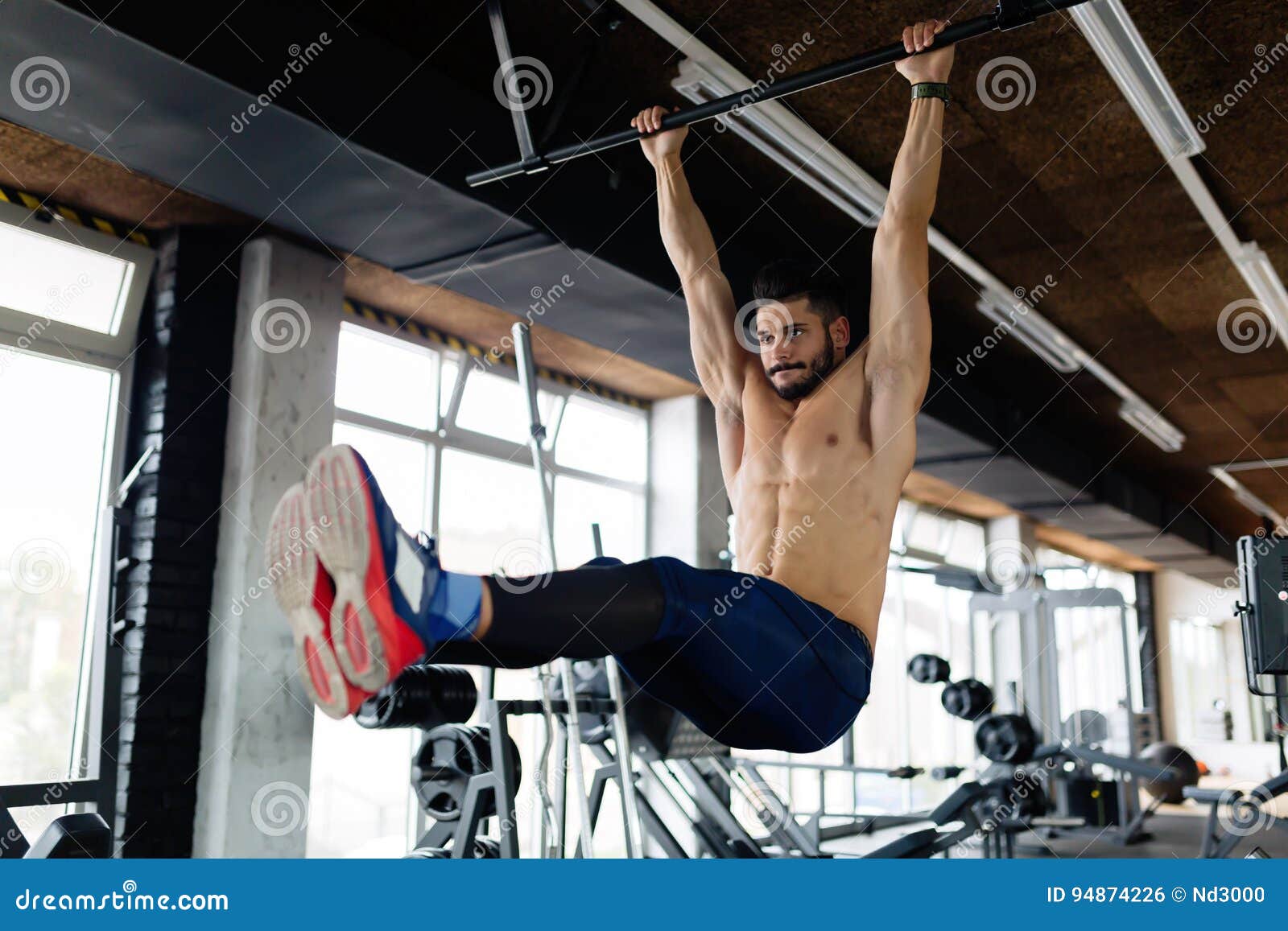 Young Man Performing Hanging Leg Raises Exercise Stock Photo - Image of ...