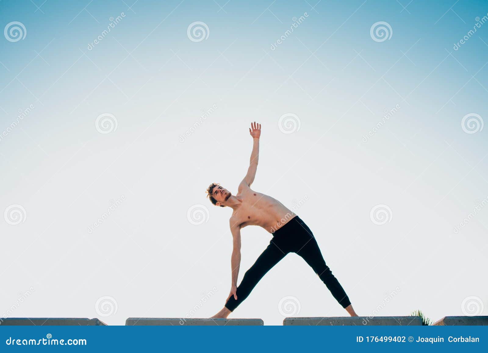 Young Man Performing Joint Movement Exercise Inspired by Yoga, Outdoors ...