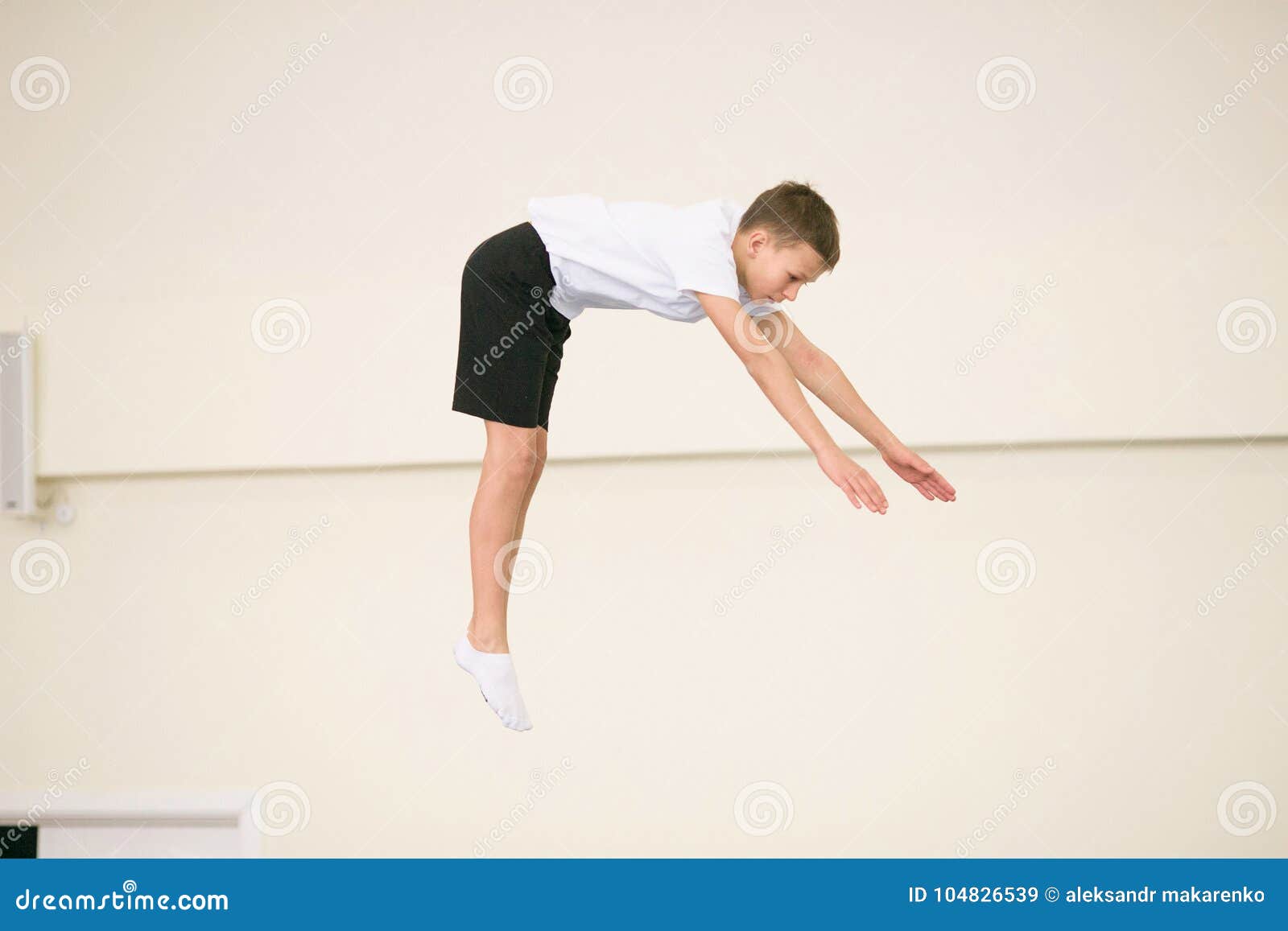 The Young Man Performs Gymnastic Exercises in the Gym. Stock Image ...