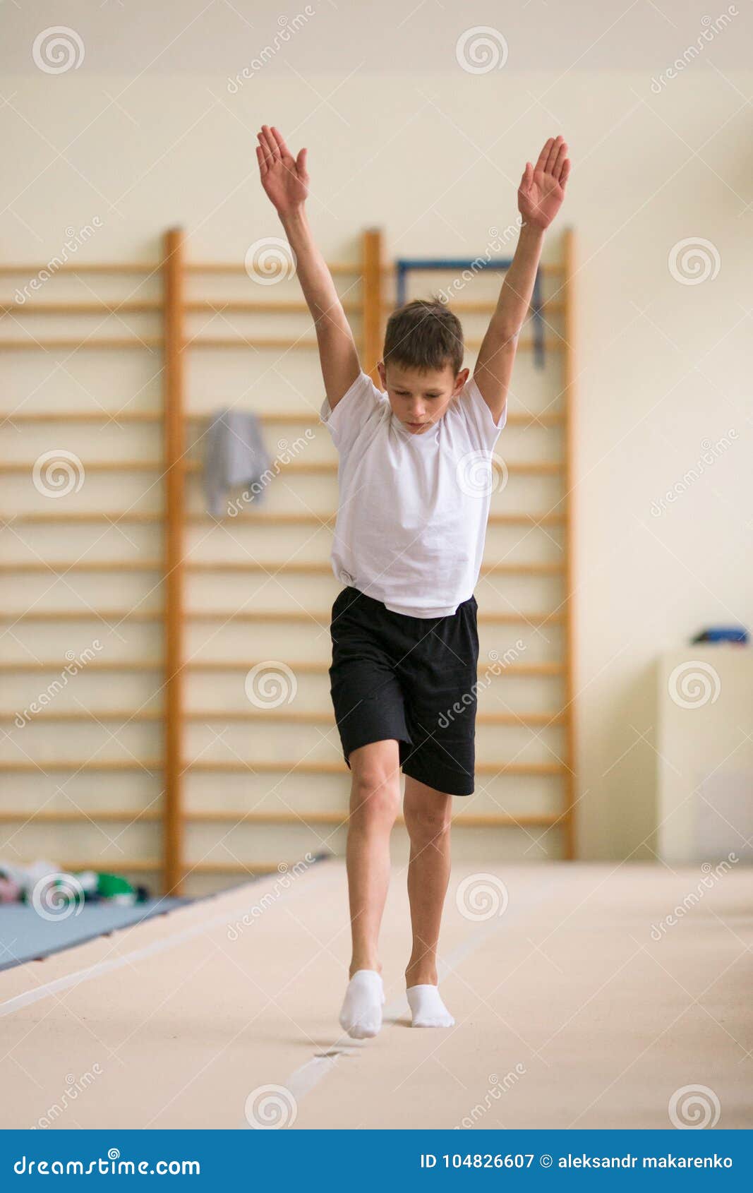The Young Man Performs Gymnastic Exercises in the Gym. Stock Image ...