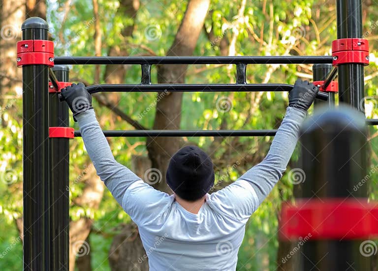 A Young Man Performs a Sports Exercise Pulling on the Simulator ...