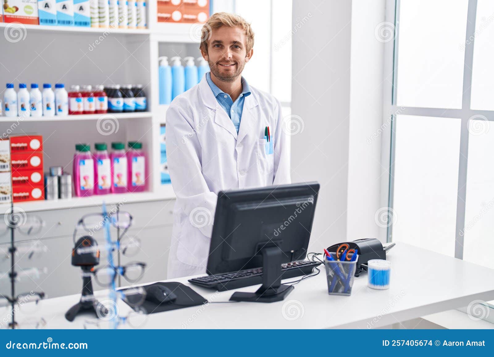 Young Man Pharmacist Using Computer Working at Pharmacy Stock Photo ...