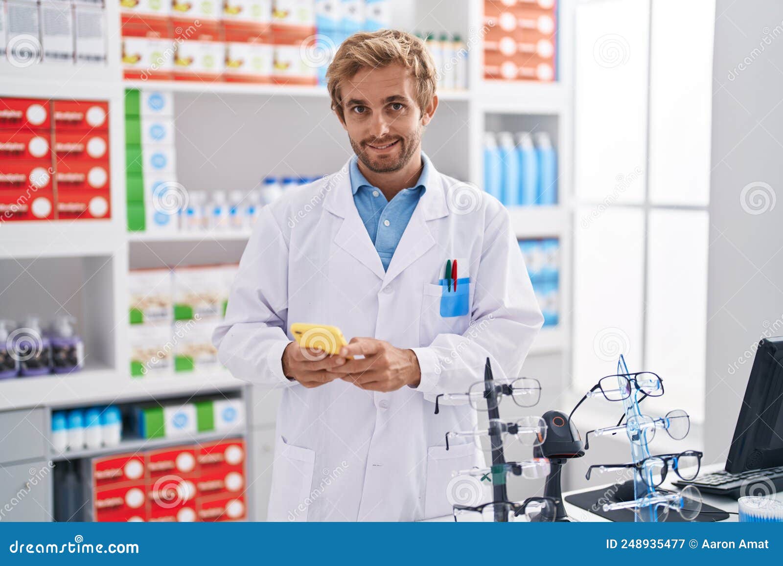 Young Man Pharmacist Using Smartphone Working at Pharmacy Stock Image ...