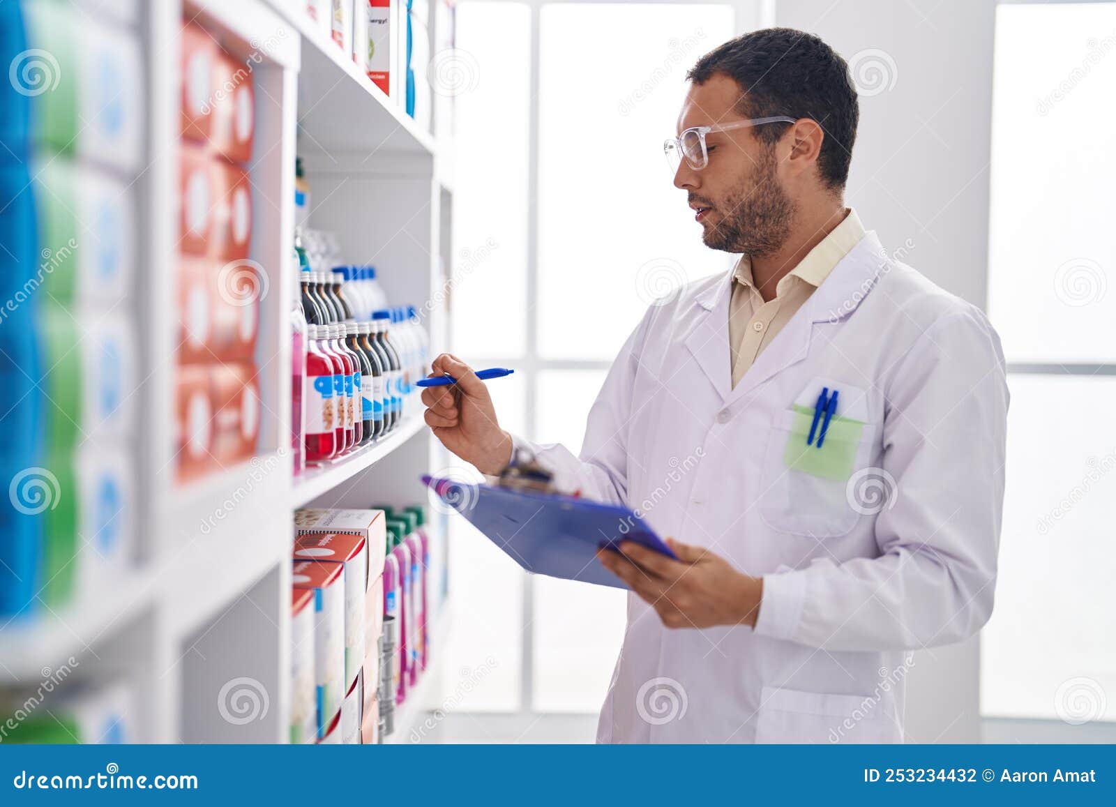 Young Man Pharmacist Writing on Document Organize Shelving at Pharmacy ...