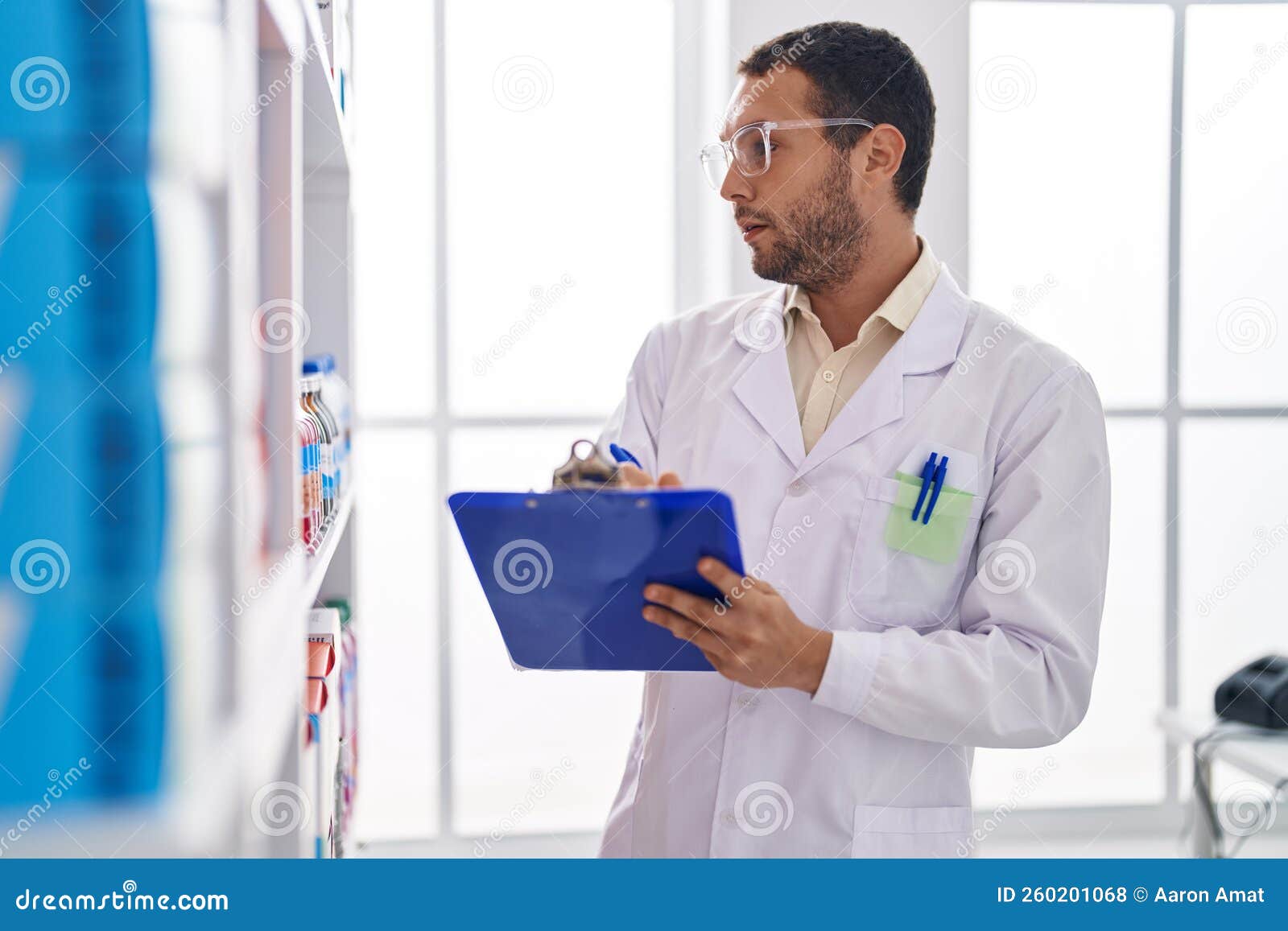 Young Man Pharmacist Writing on Document Organize Shelving at Pharmacy ...