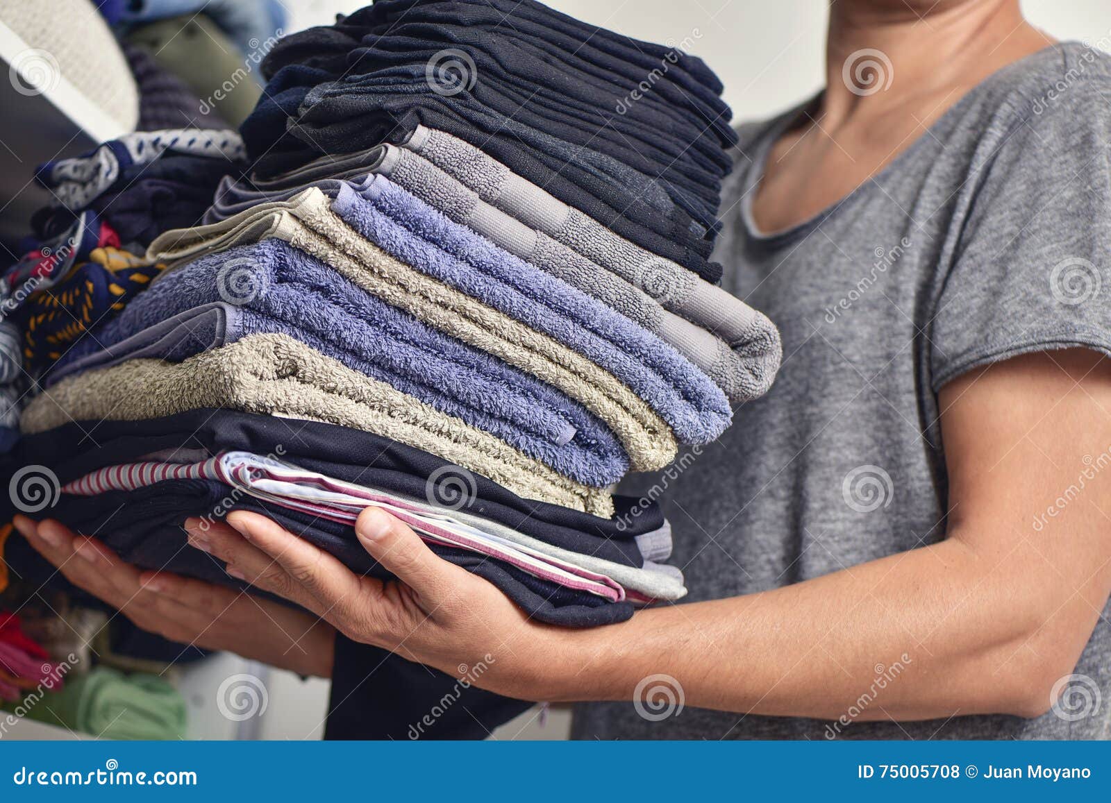 Young Man with a Pile of Folded Clothes Stock Photo - Image of gender ...