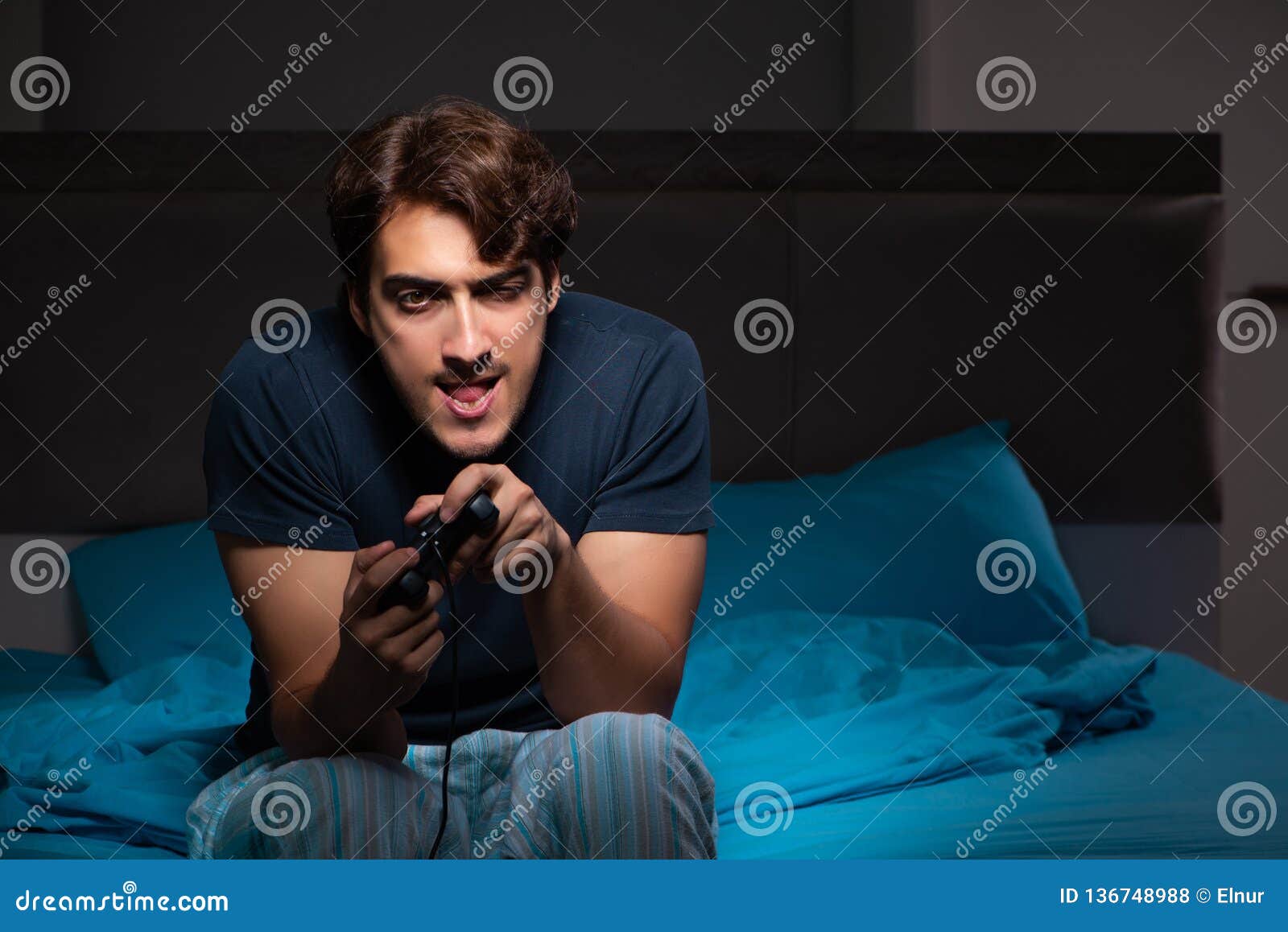 The Young Man Playing Computer Games at Night in Bed Stock Photo ...