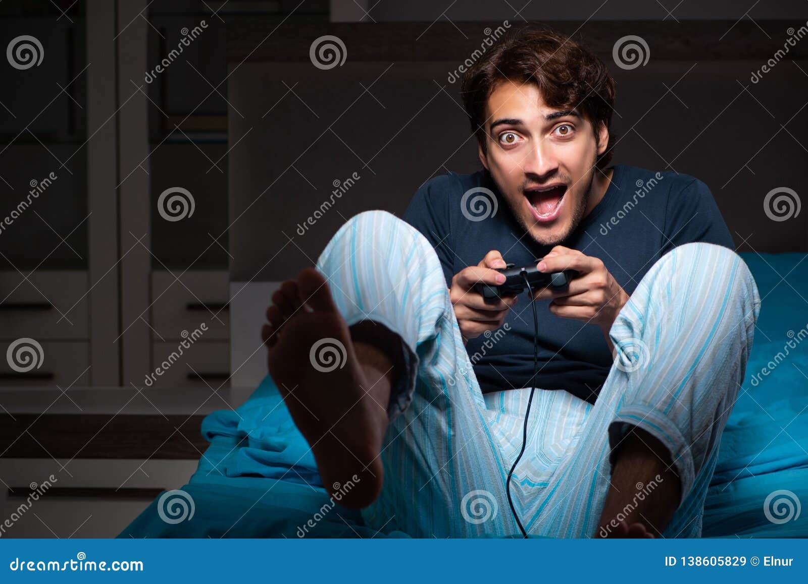 The Young Man Playing Computer Games at Night in Bed Stock Image ...