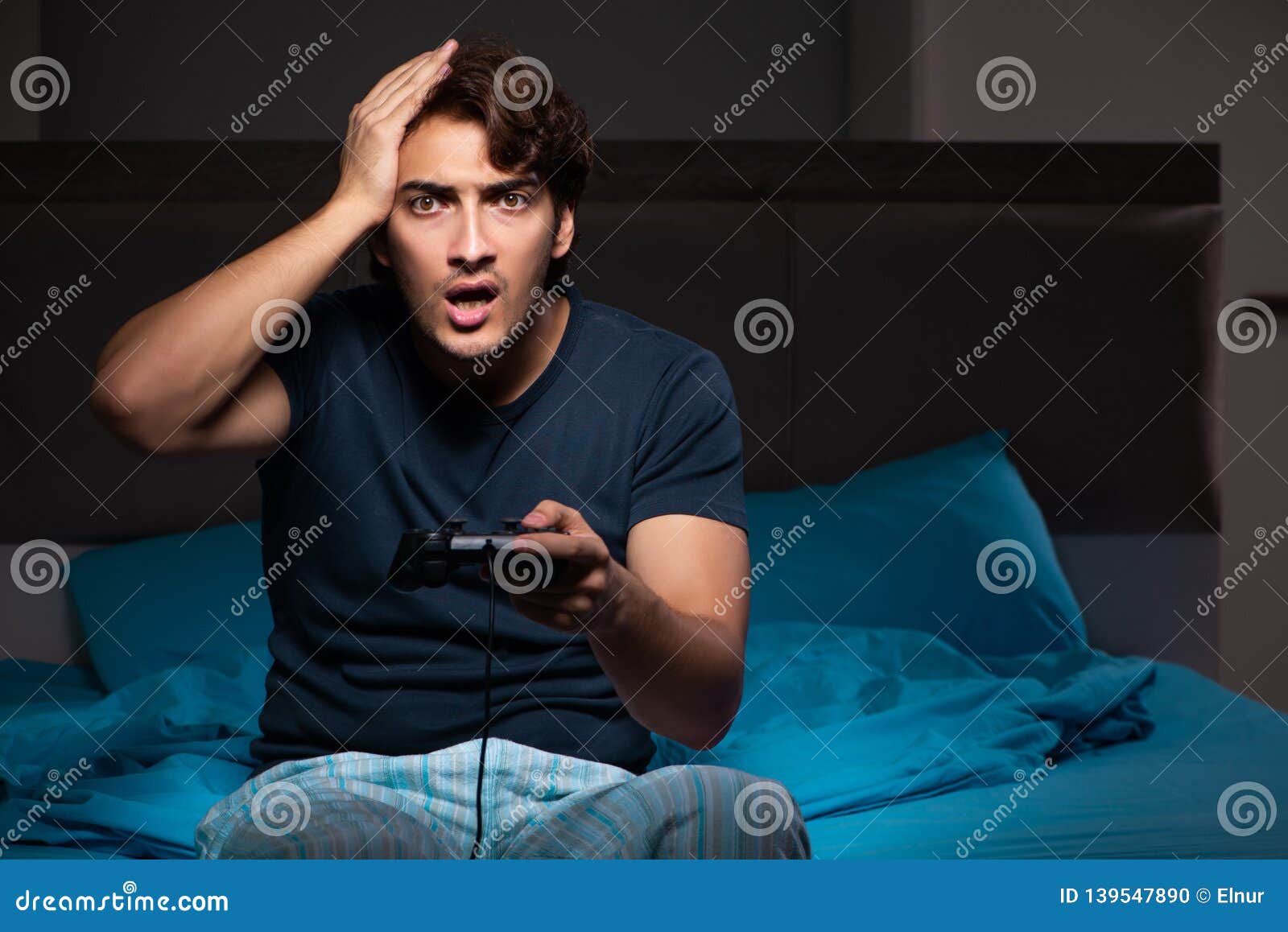 The Young Man Playing Computer Games at Night in Bed Stock Photo ...