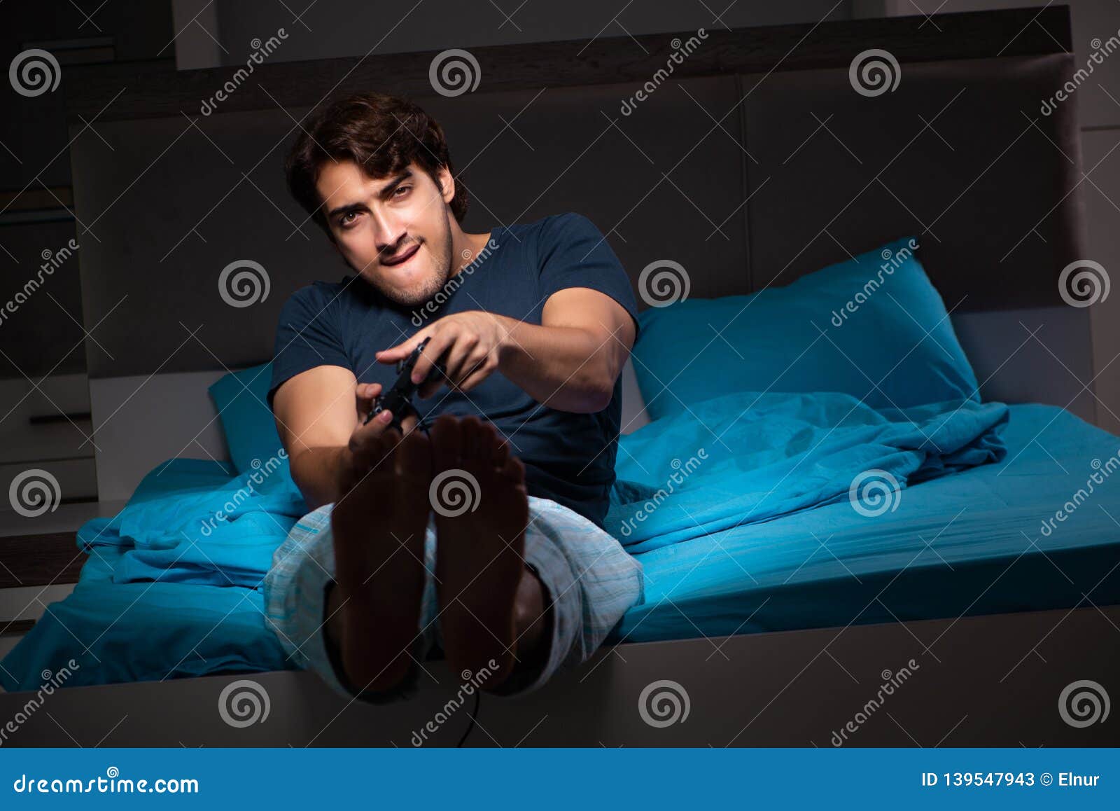 The Young Man Playing Computer Games at Night in Bed Stock Image ...