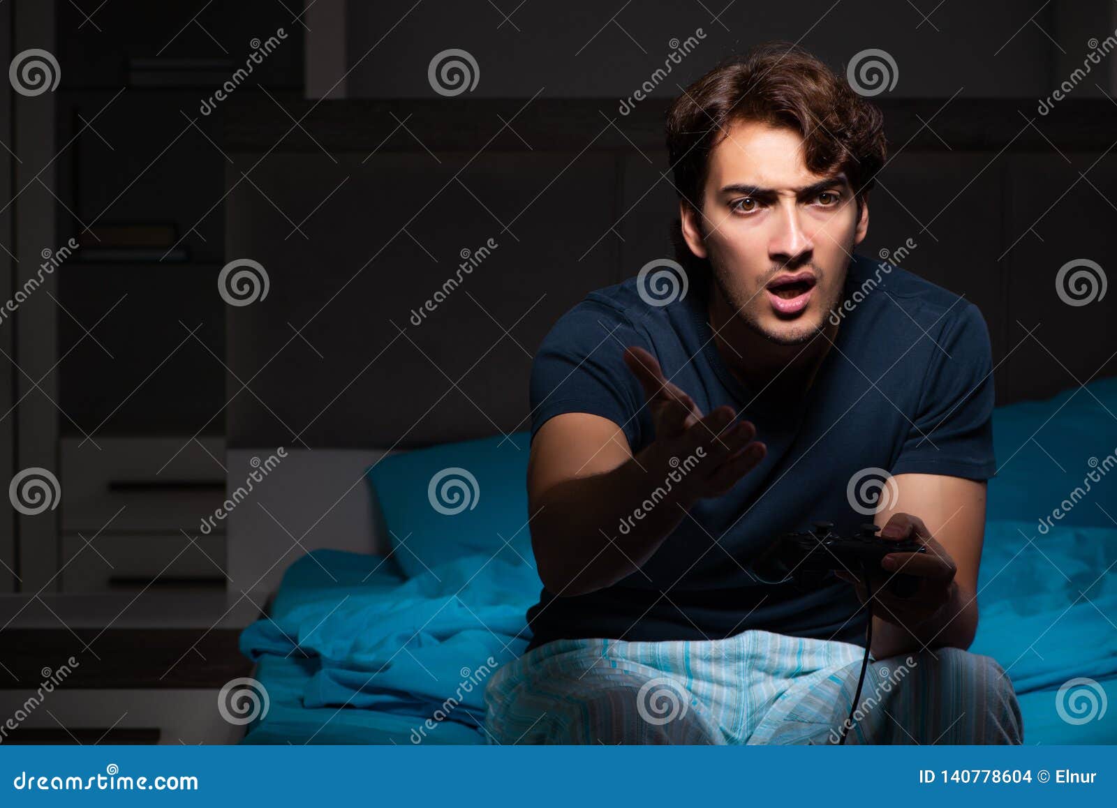 The Young Man Playing Computer Games at Night in Bed Stock Photo ...