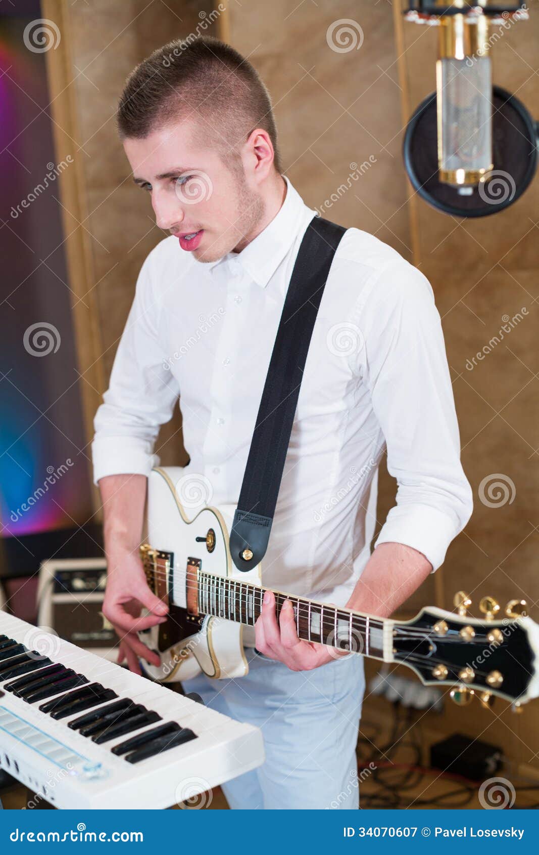 Young Man Playing Guitar Next To the Keyboards Stock Image - Image of ...