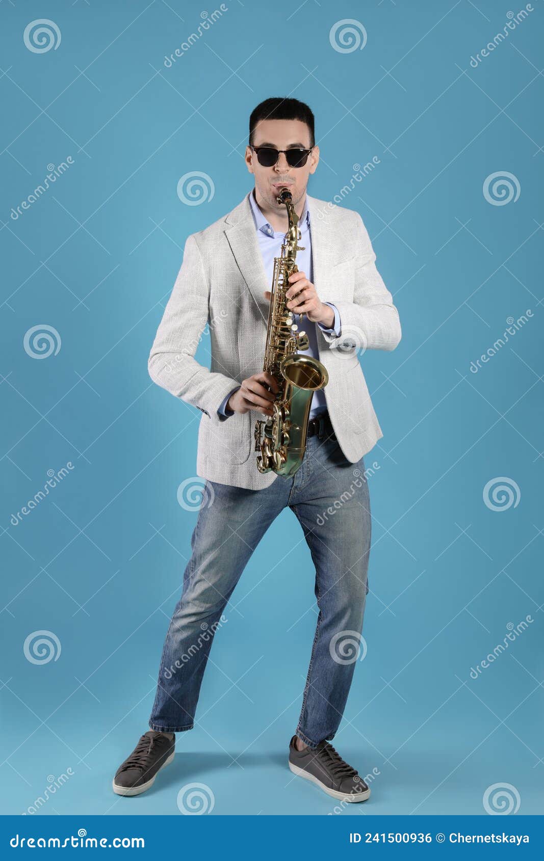 Young Man Playing Saxophone on Light Blue Background Stock Photo ...