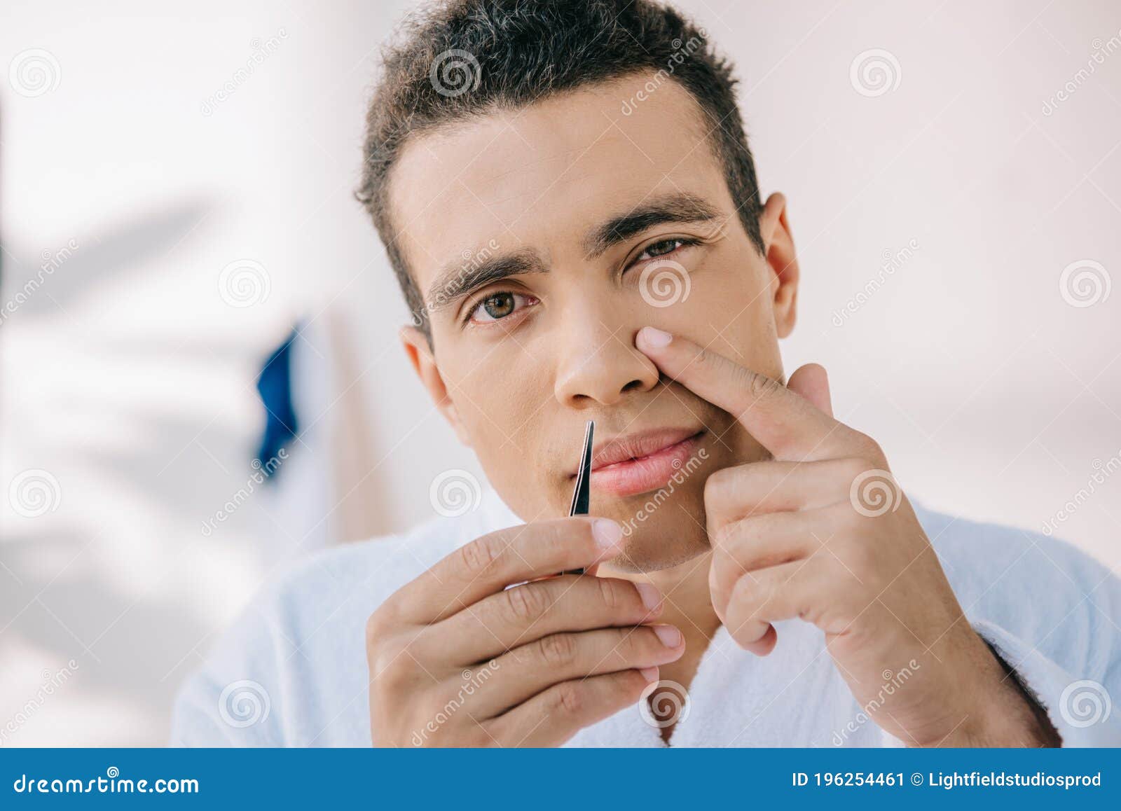 Young Man Plucking Nose with Tweezer and Looking at Camera Stock Image ...