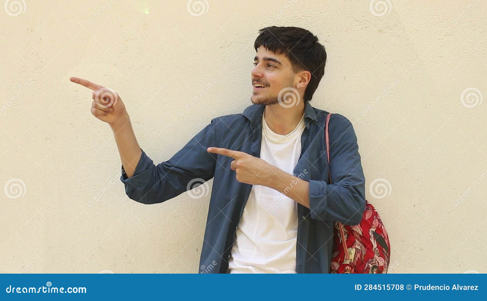 Young man pointing on wall stock footage. Video of expression - 284515708