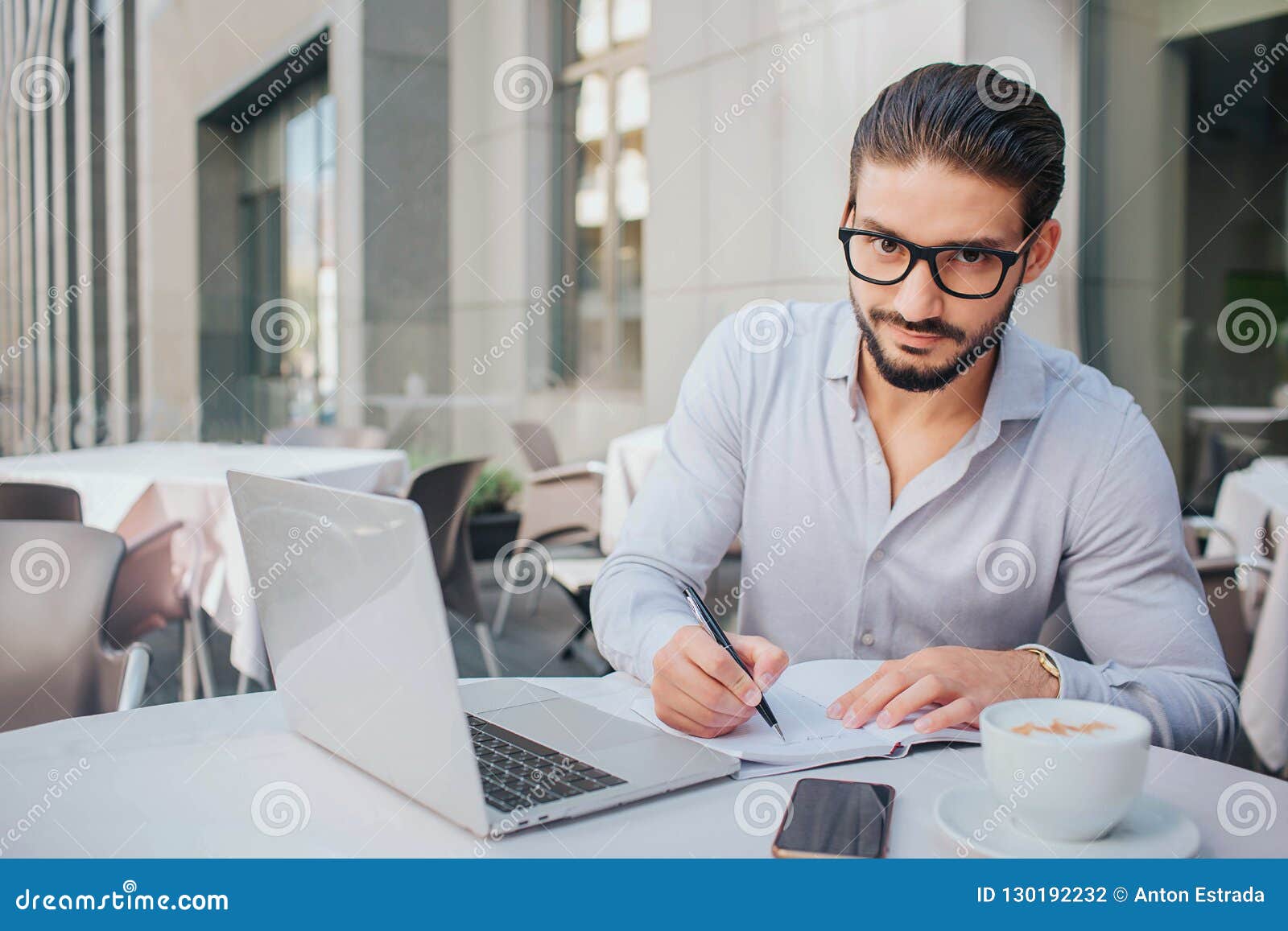 Young Man Poses. he Looks on Camera and Smiles a Bit. Also Guy Writes ...