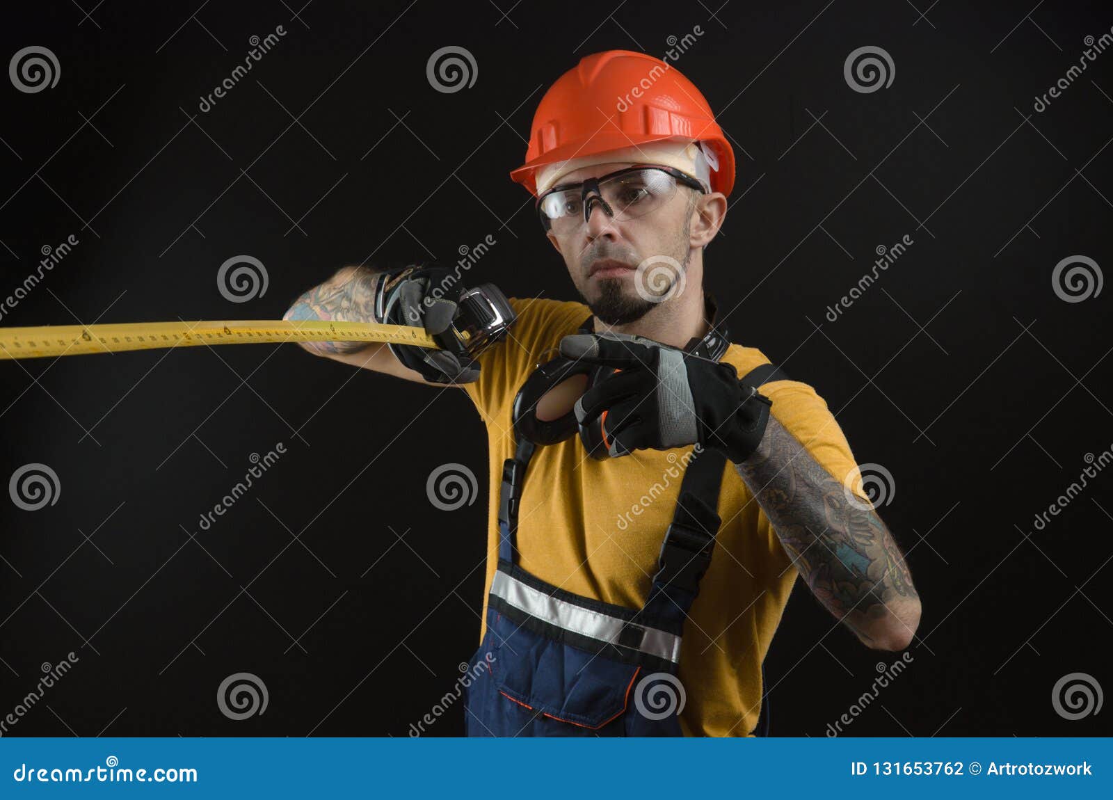 A Young Man Posing on a Black Background in a Work Uniform and a ...