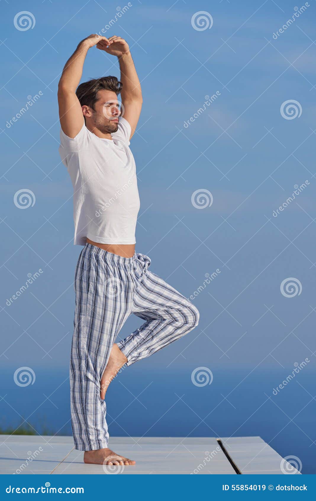 Young man practicing yoga stock image. Image of health - 55854019