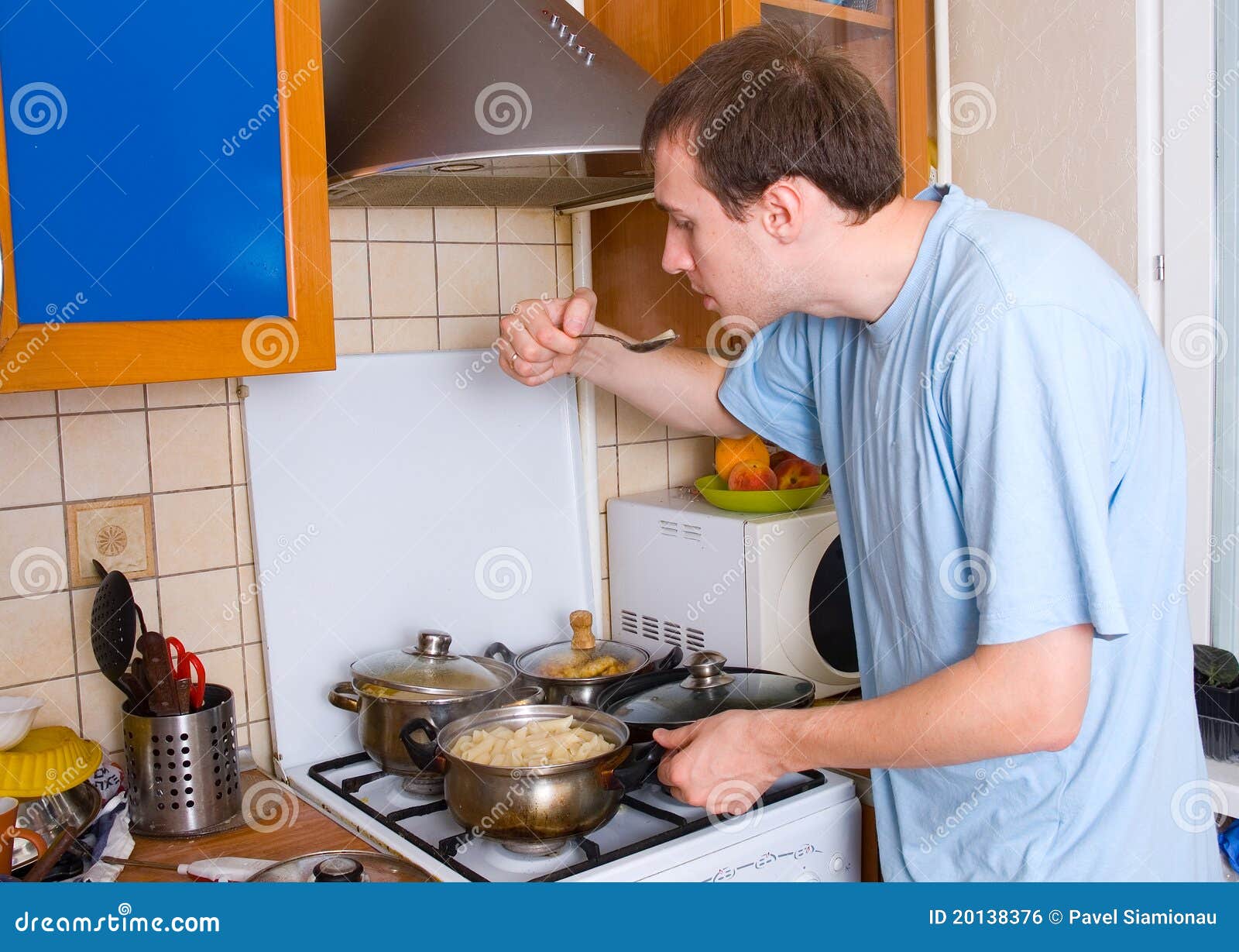 Young man preparing food stock photo. Image of cooker - 20138376